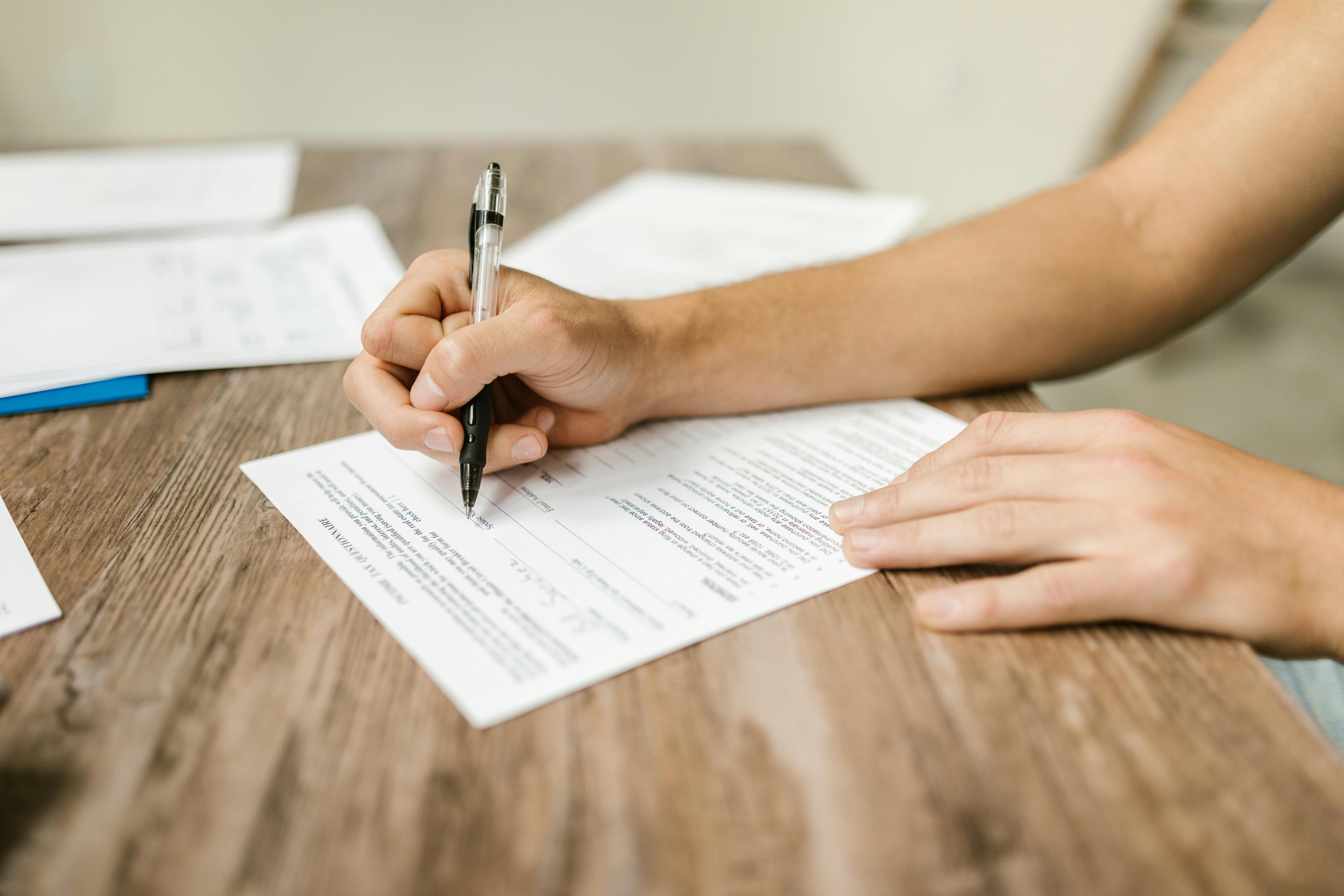 Close-Up Shot of a Person Filling Out a Questionnaire · Free Stock Photo