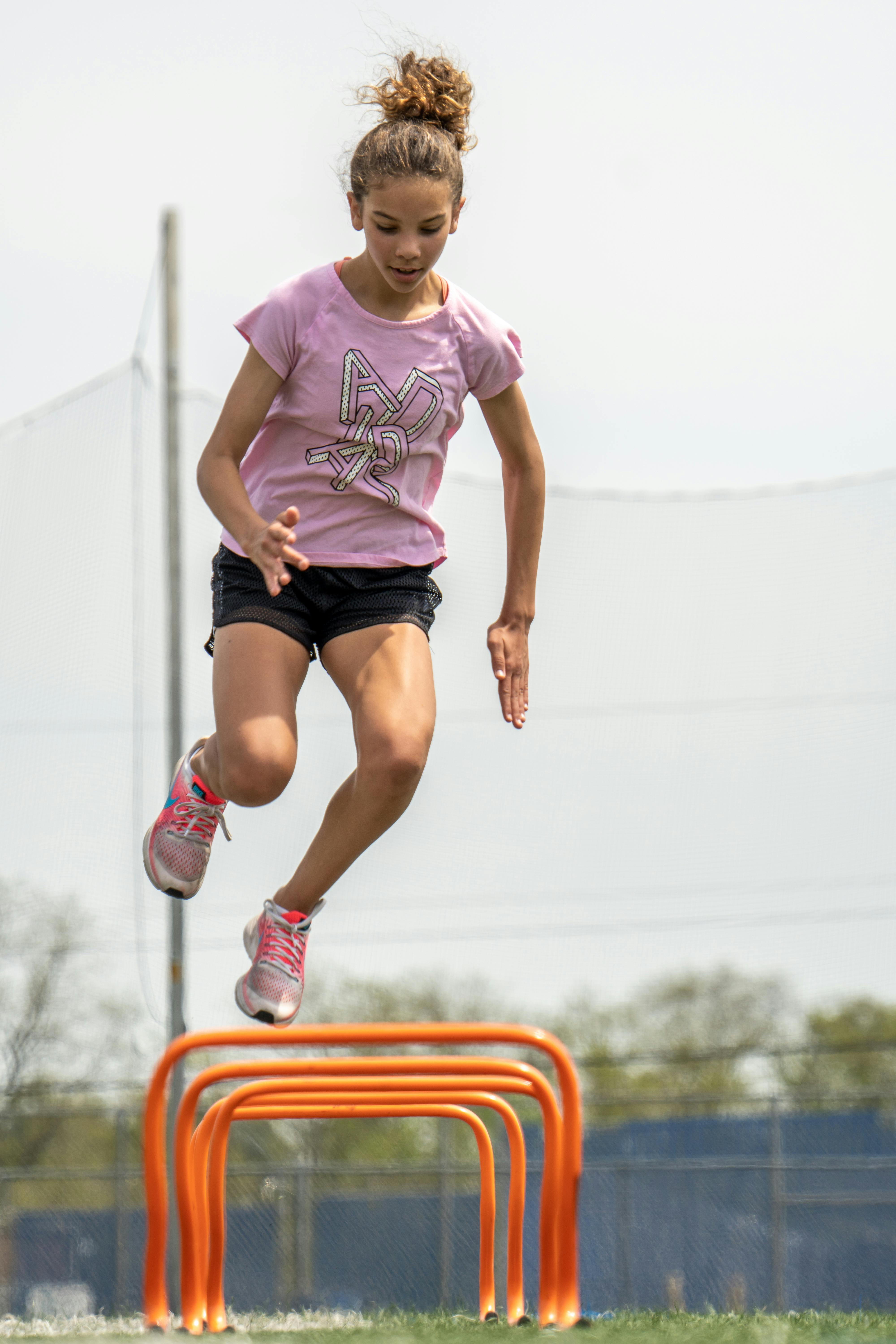 Girl in a Pink Shirt and Black Shorts Jumping · Free Stock Photo