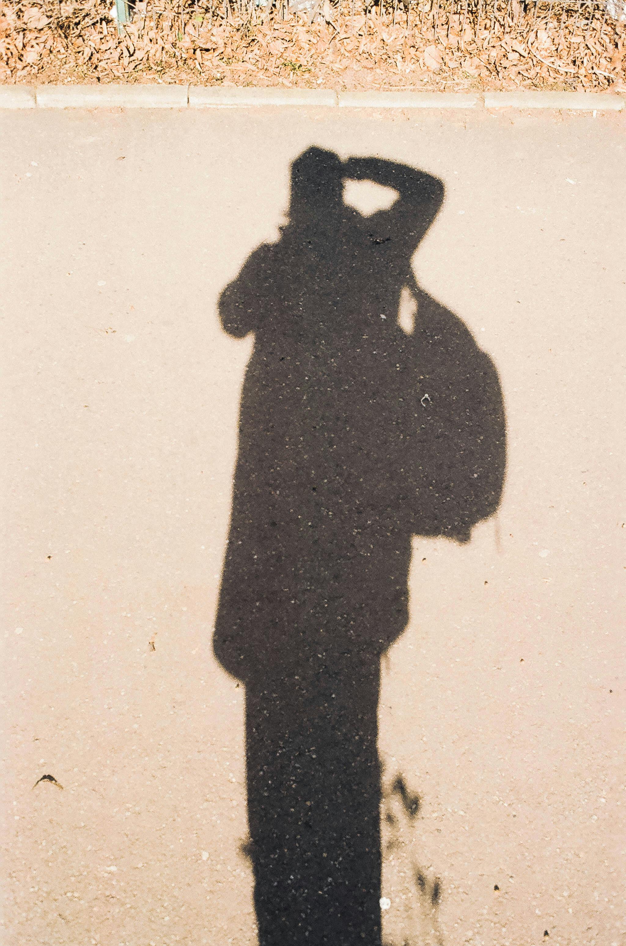 Shadows of Persons on White Concrete Wall · Free Stock Photo