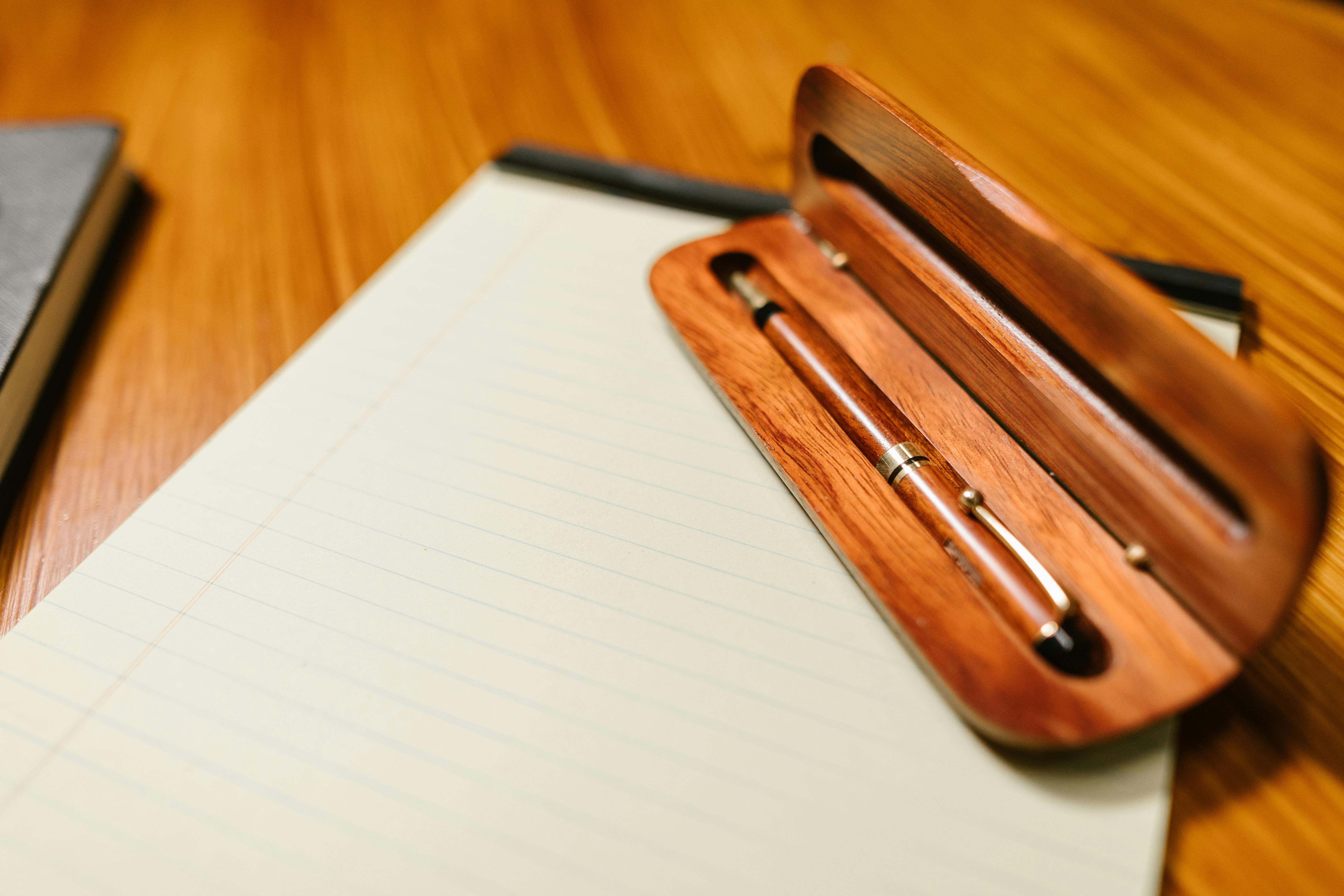 Person Holding White Paper on a Notebook · Free Stock Photo