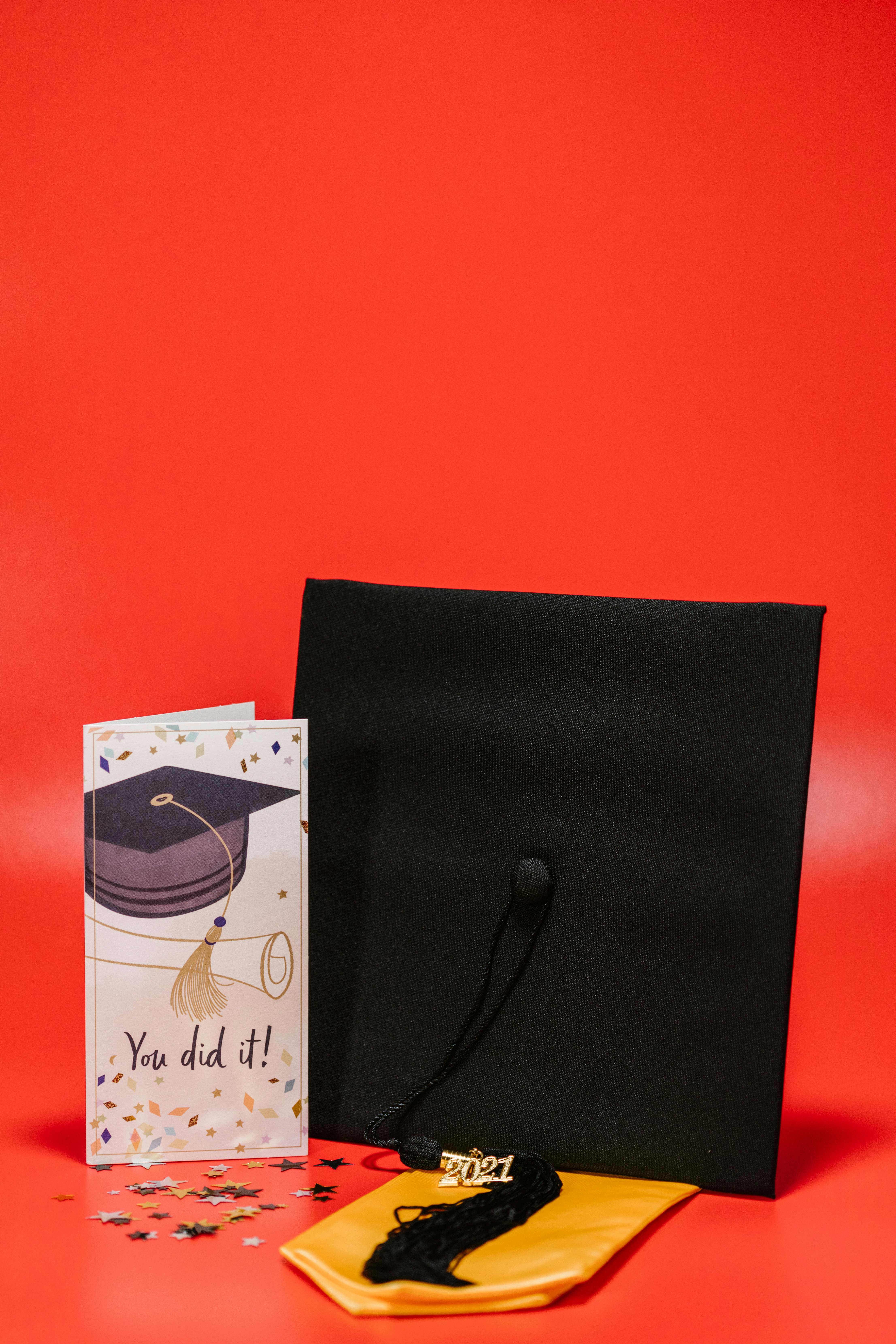 Black Card Beside Graduation Cap · Free Stock Photo