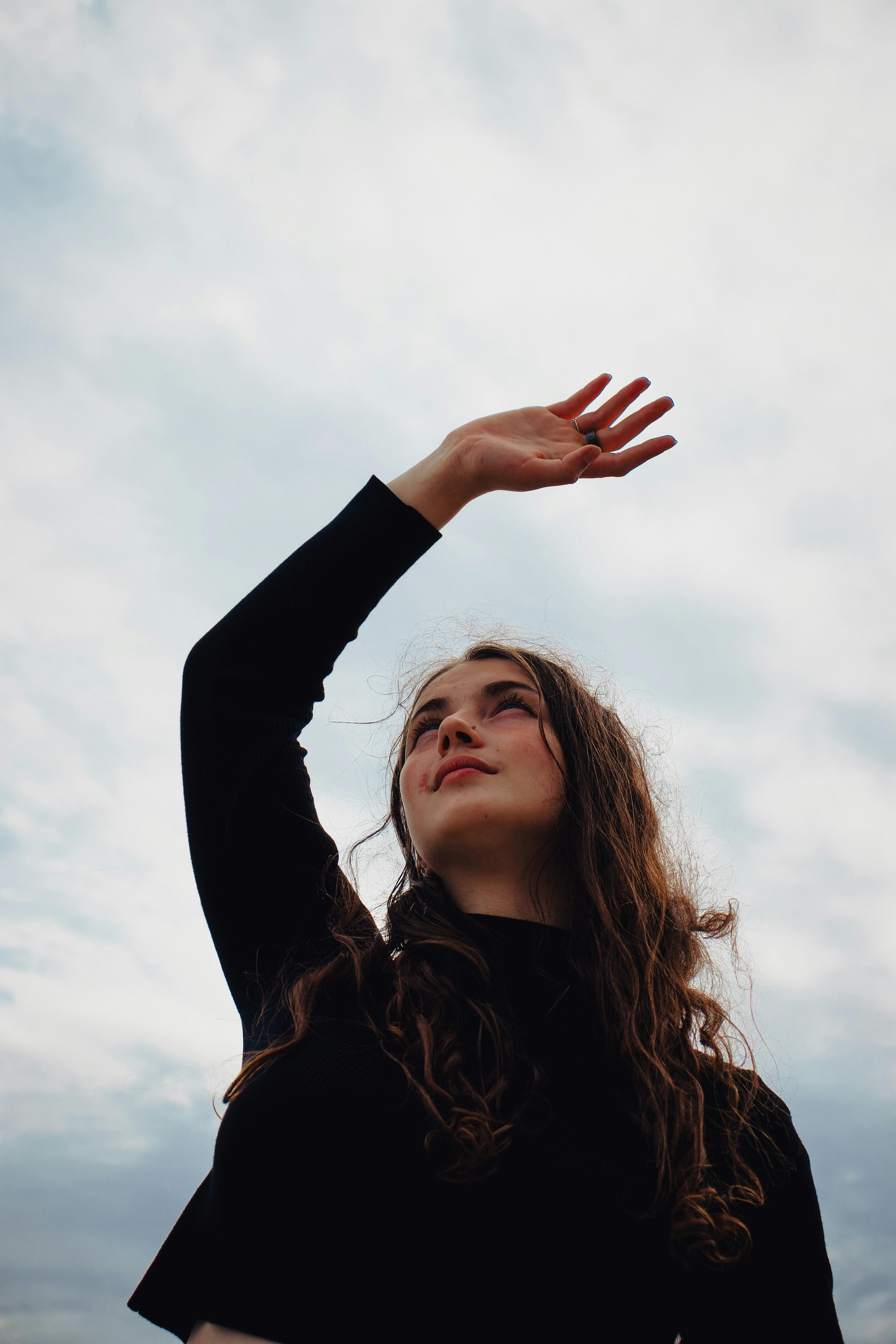 Low angle view of woman with hands raised · Free Stock Photo