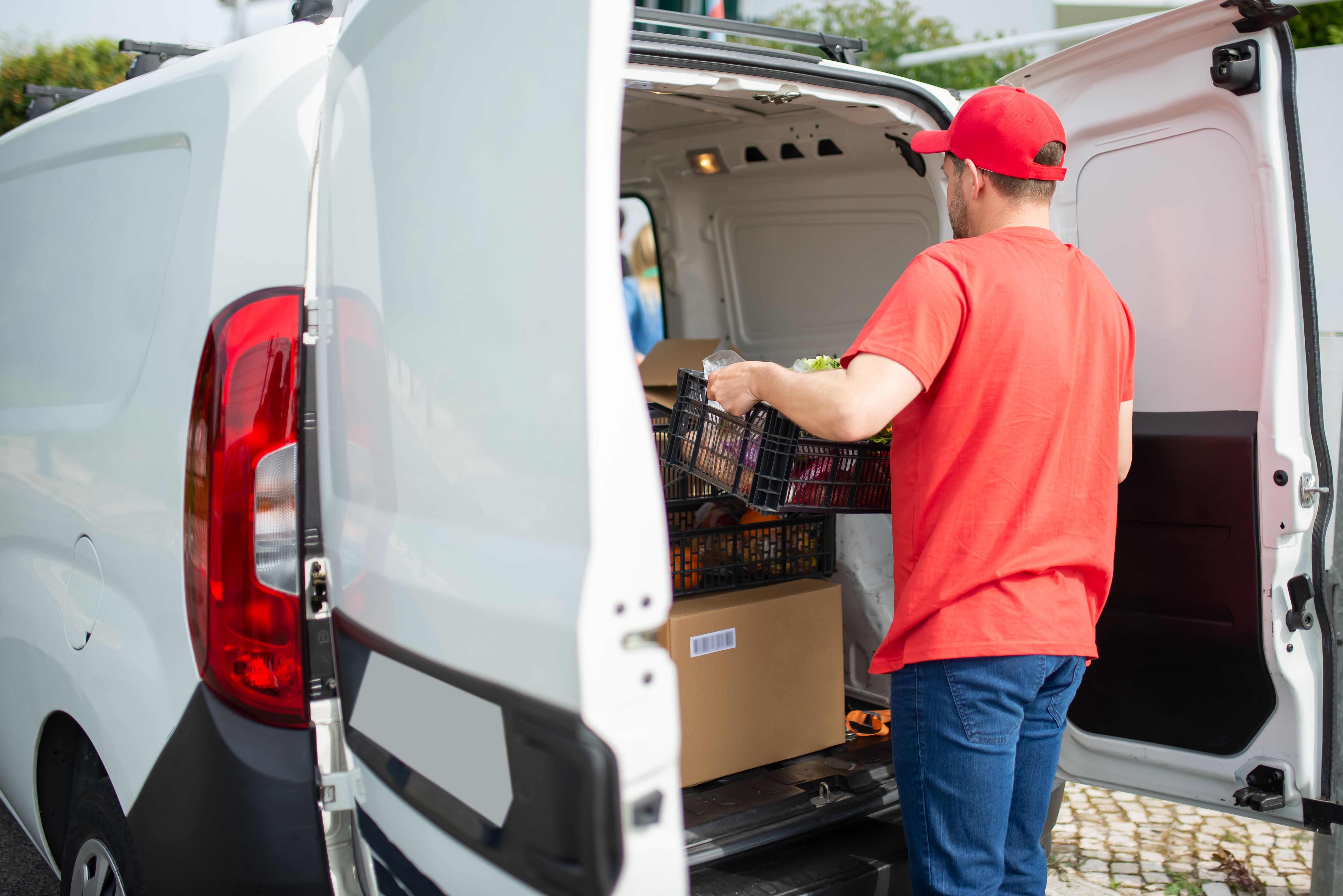 Man Carrying Boxes Beside a Van · Free Stock Photo