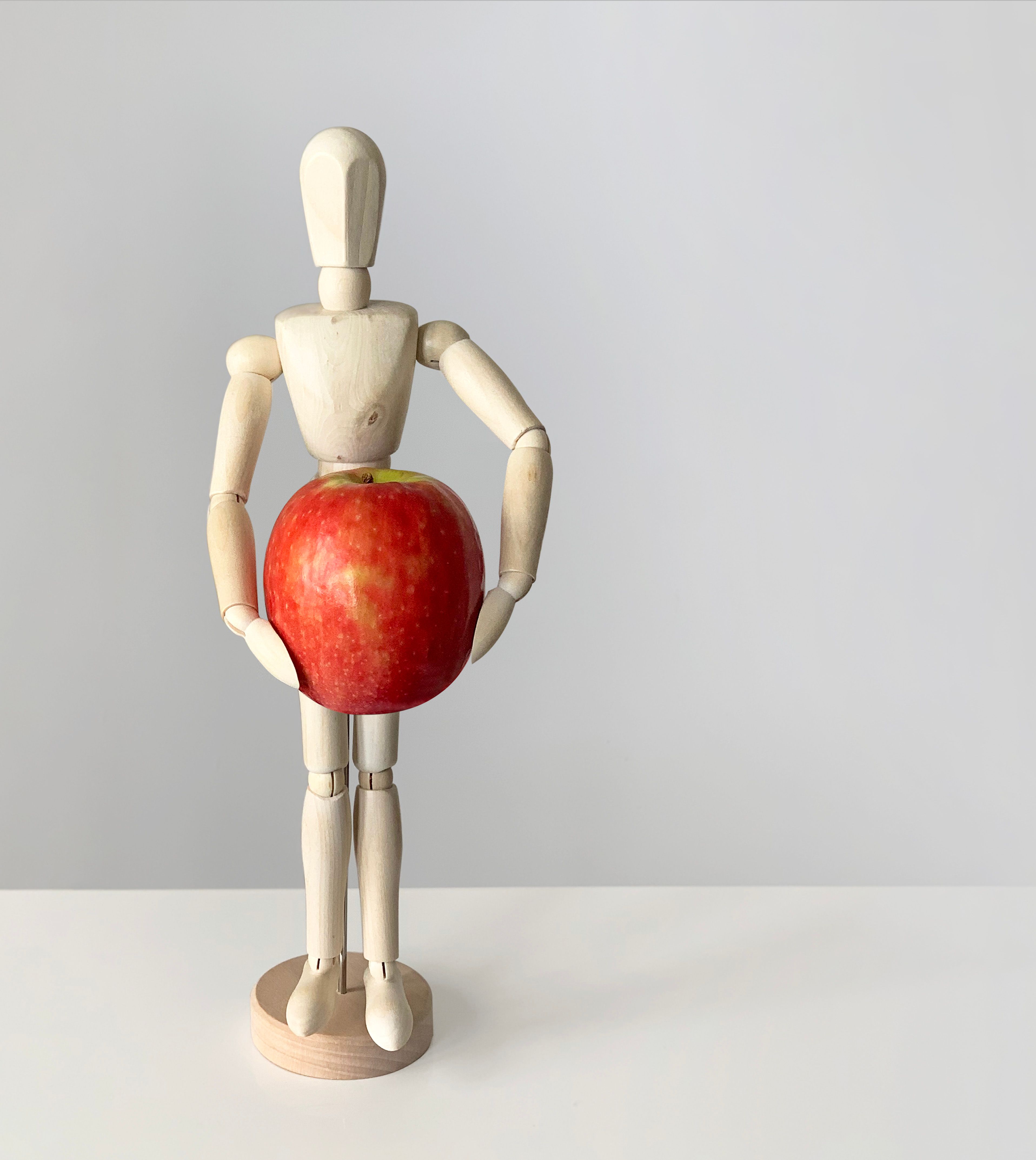 A Figurine Holding a Red Apple · Free Stock Photo