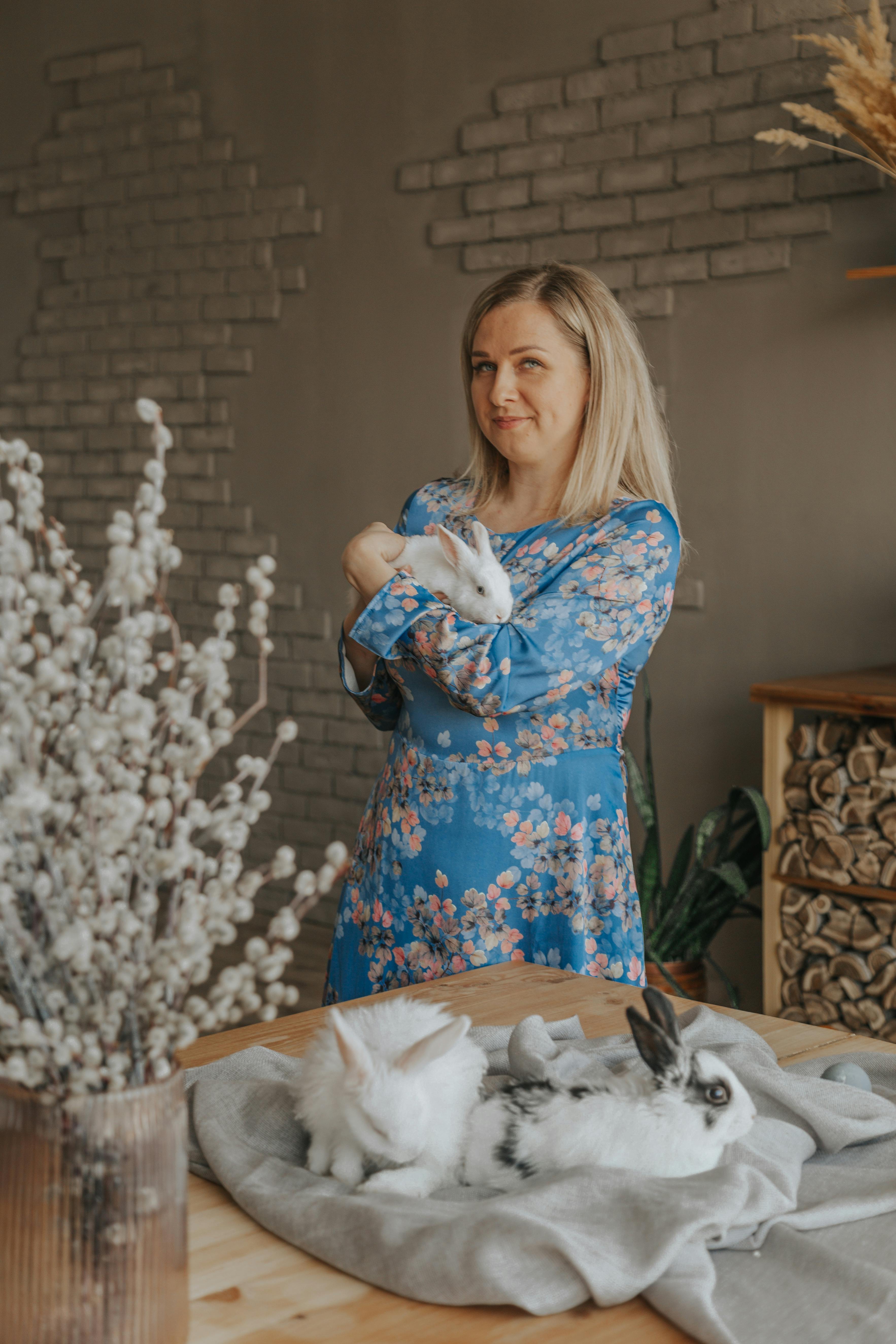 Friendly woman embracing rabbit in loft house room · Free Stock Photo