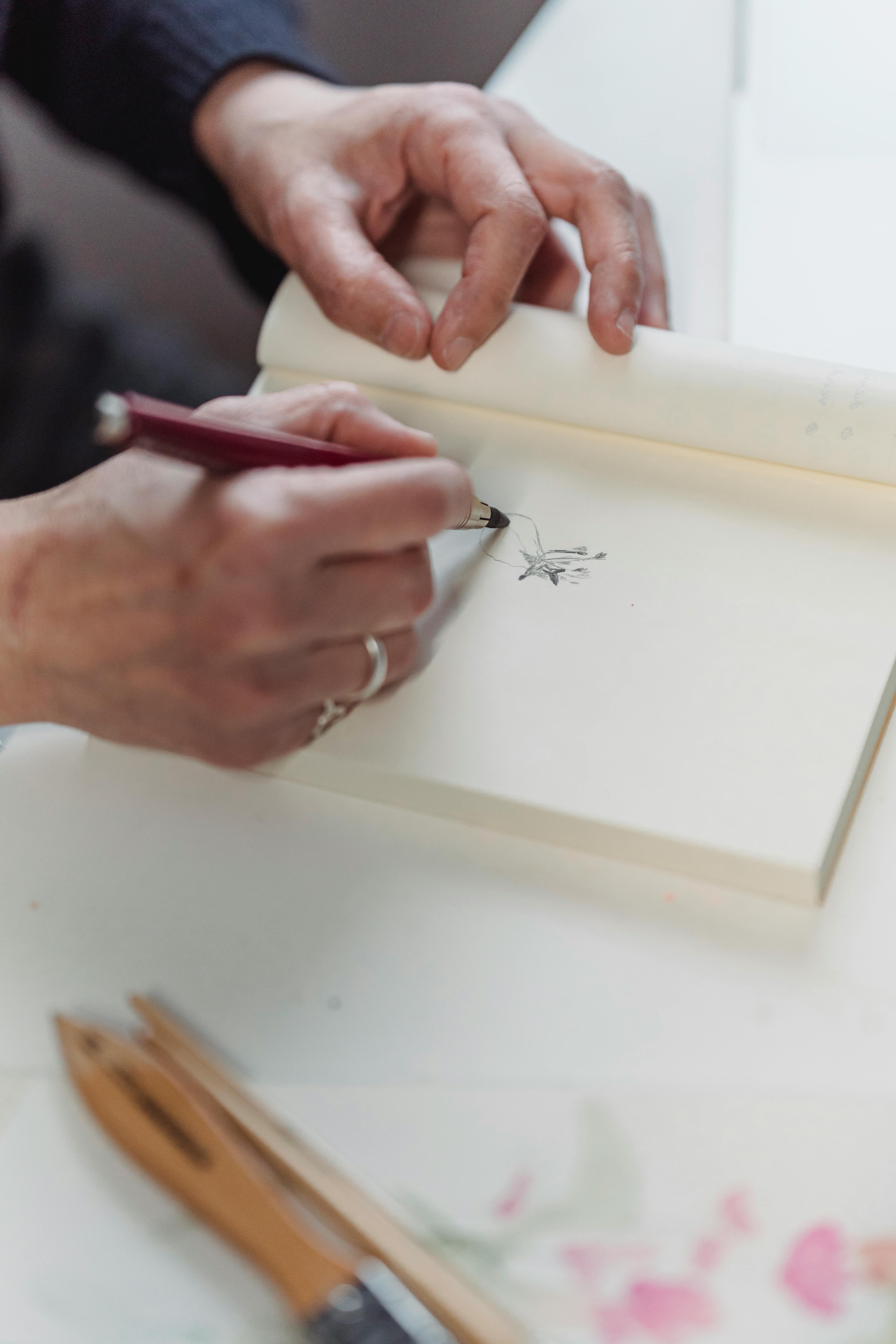 Close-Up Shot of a Person Drawing an Artwork · Free Stock Photo