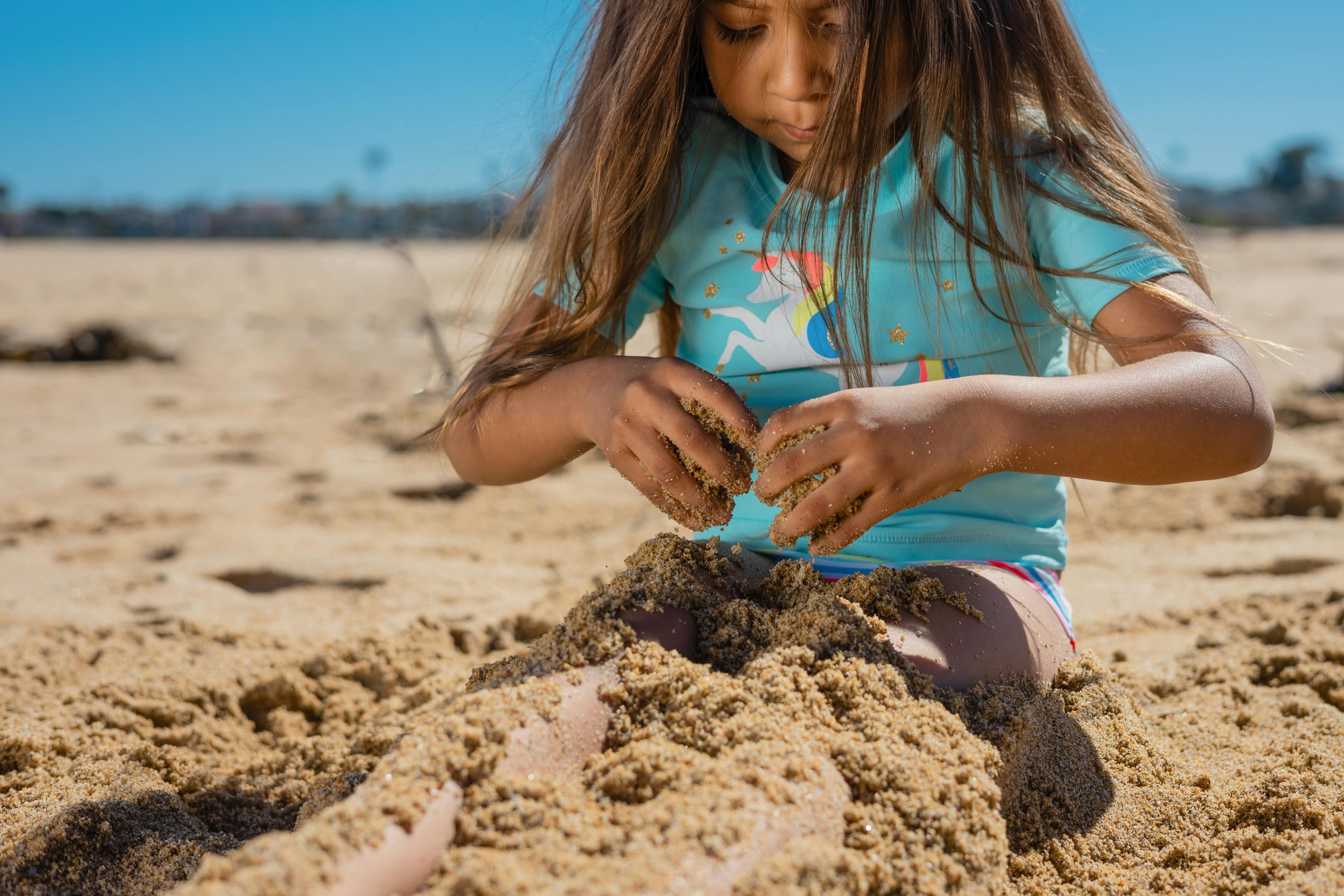 Kid Playing with Beach Sand · Free Stock Photo