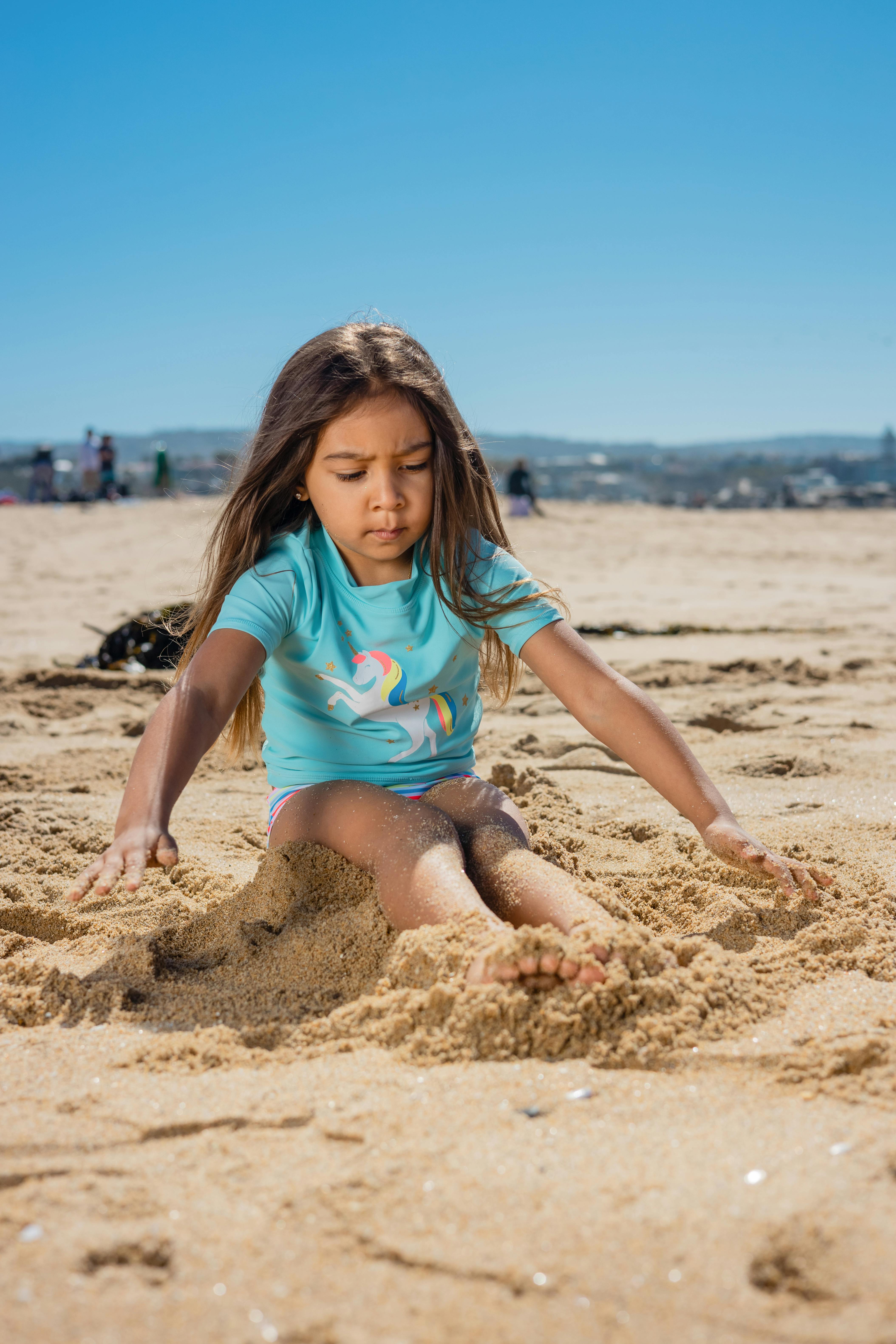Pretty Little Girl Digging on Beach Sand · Free Stock Photo