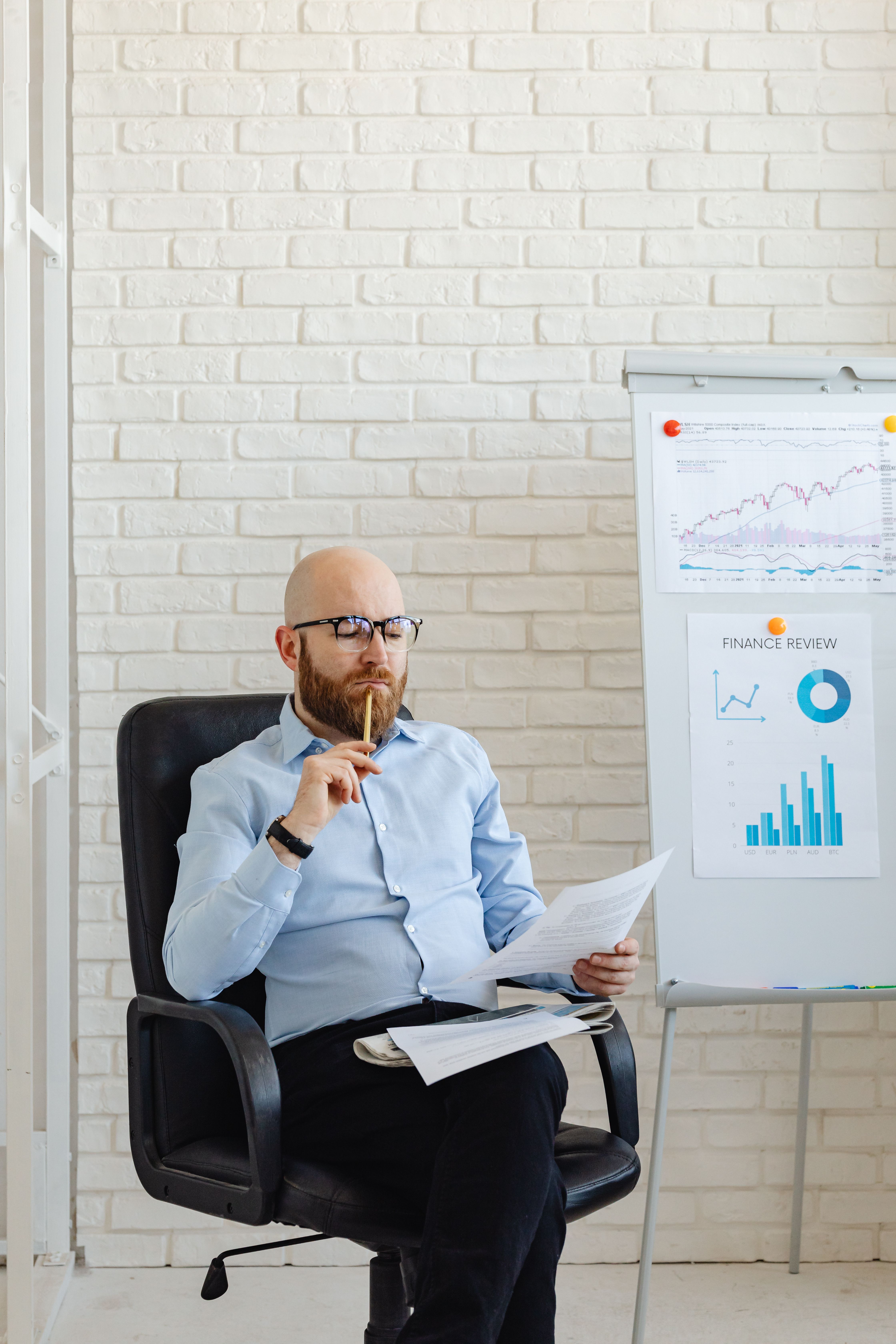A Man Looking at Charts and Graphs on a Whiteboard · Free Stock Photo