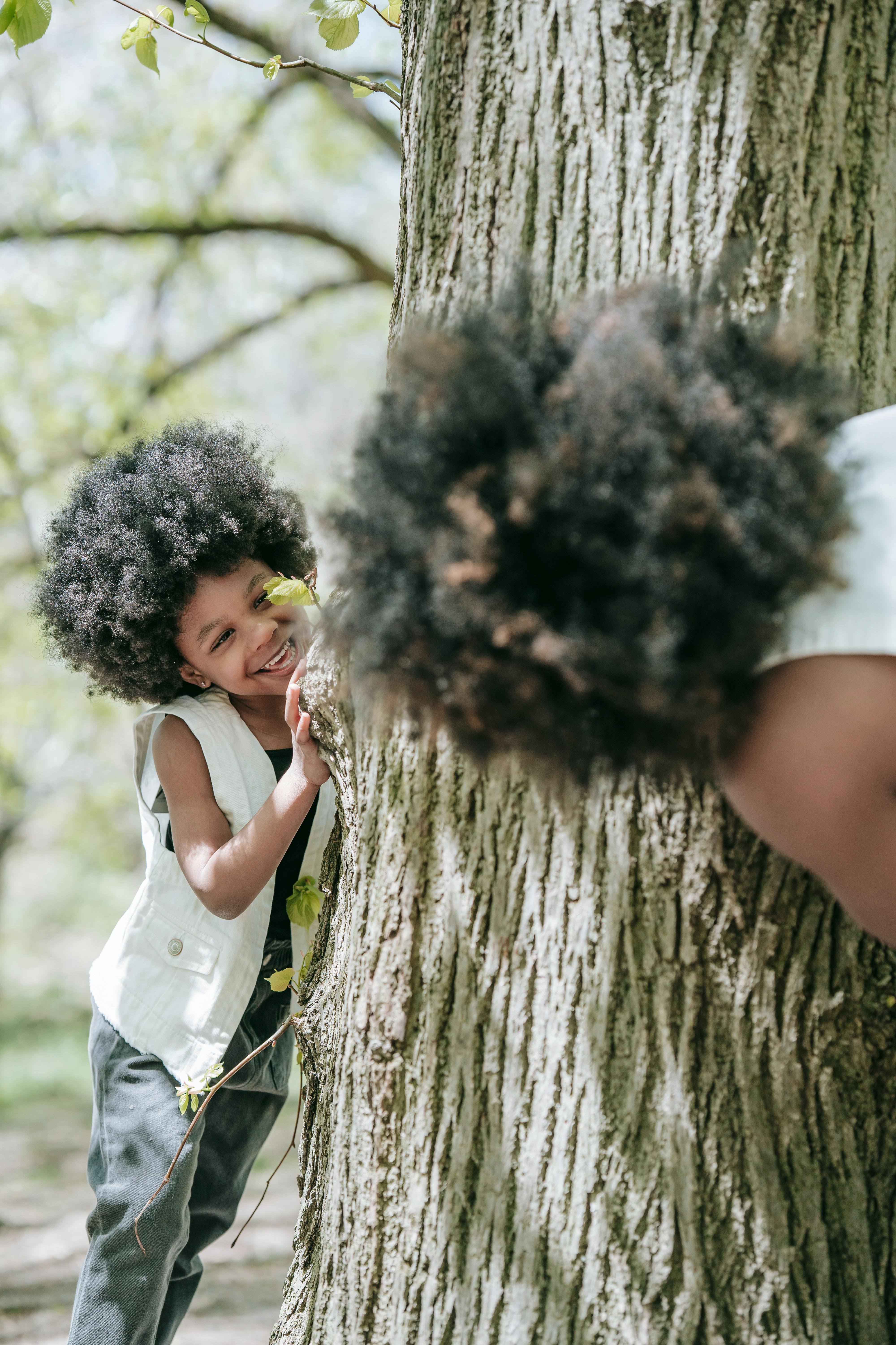 Anonymous black little kid hiding in wardrobe · Free Stock Photo