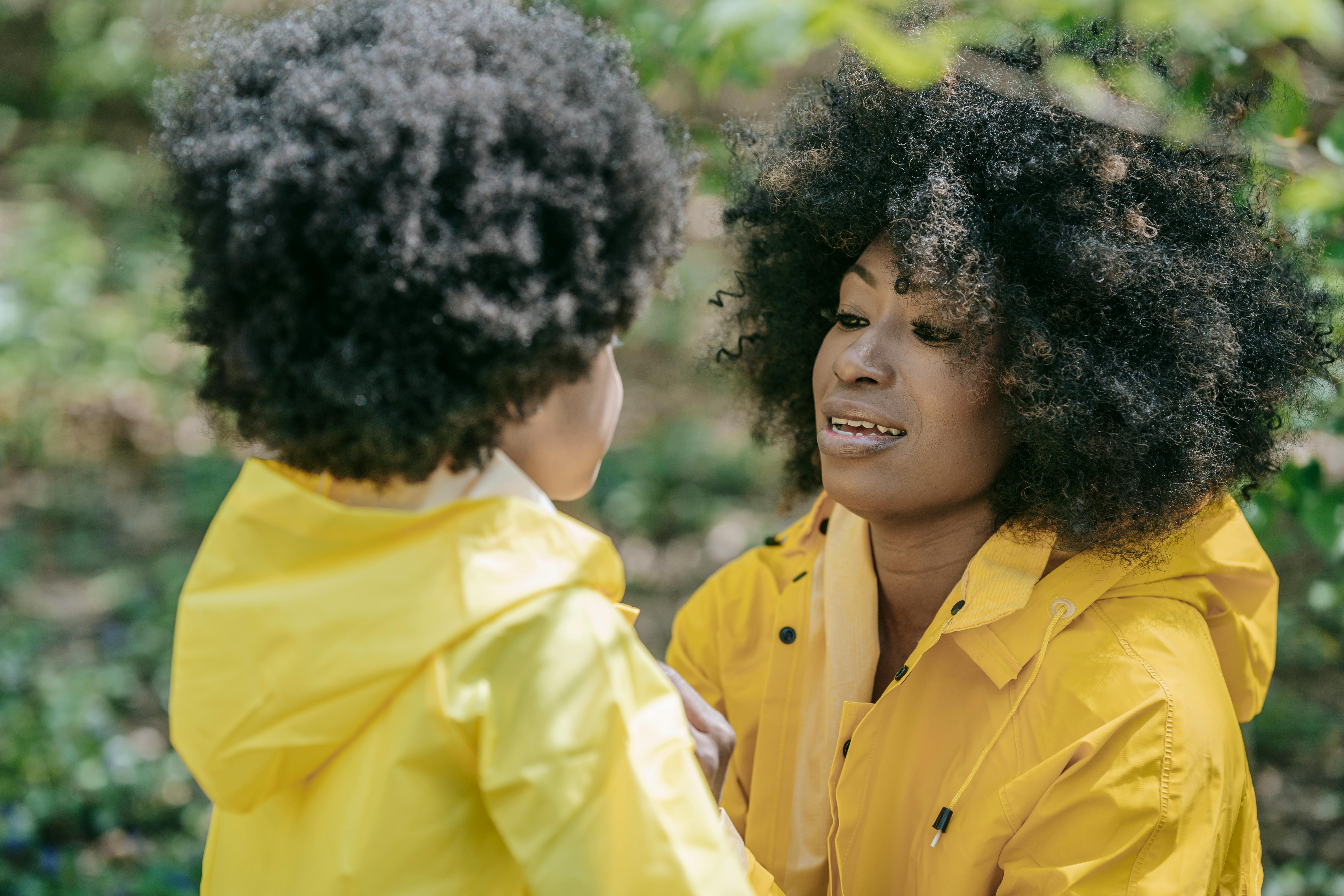 A Woman Putting On a Yellow Jacket on the Child · Free Stock Photo