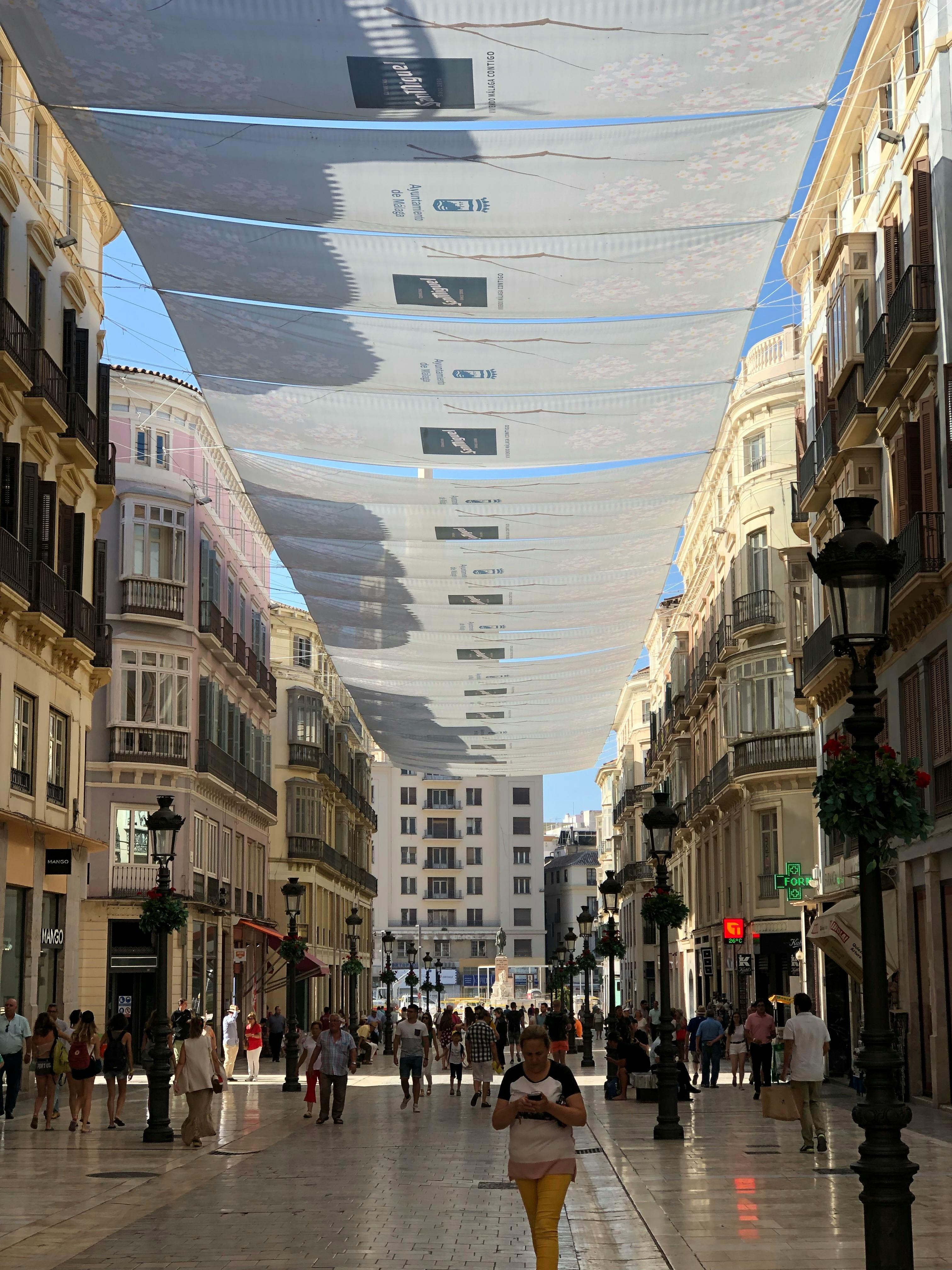 People Walking Between Buildings on City Street · Free Stock Photo