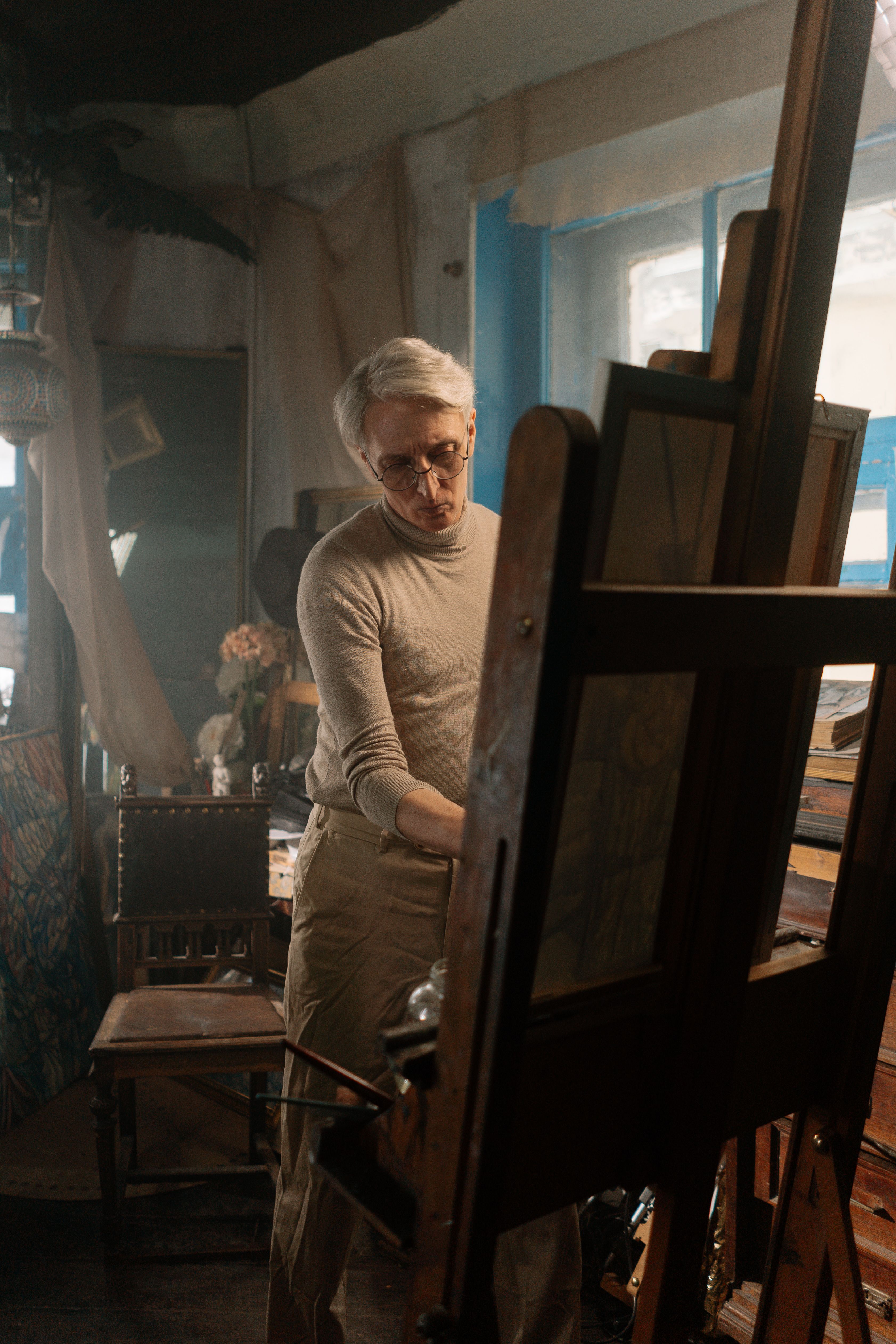 Sitting Man Looking at Drawings · Free Stock Photo
