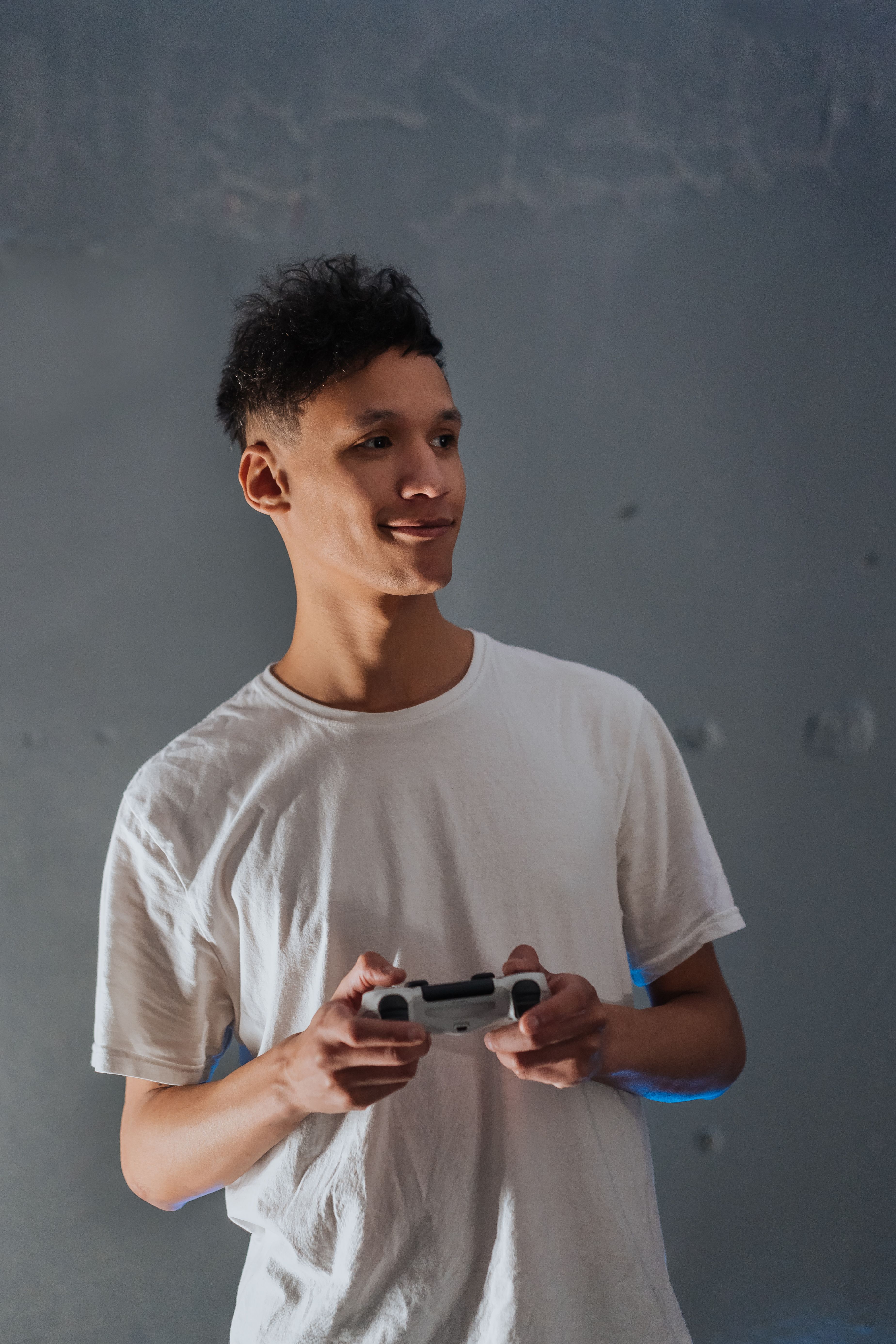 Man in White Shirt holding a Gaming Console · Free Stock Photo