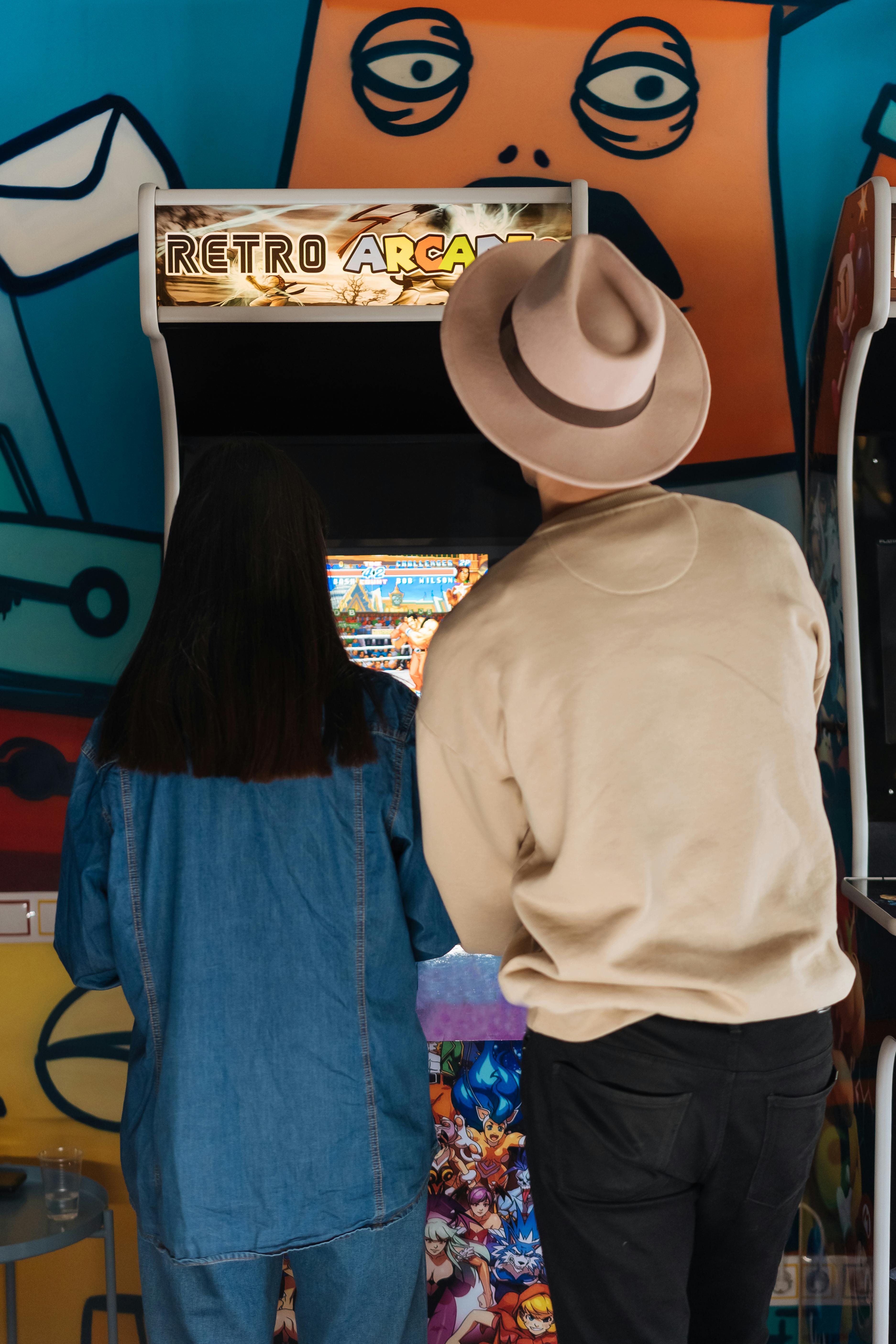Back View of a Woman Playing an Arcade Machine · Free Stock Photo