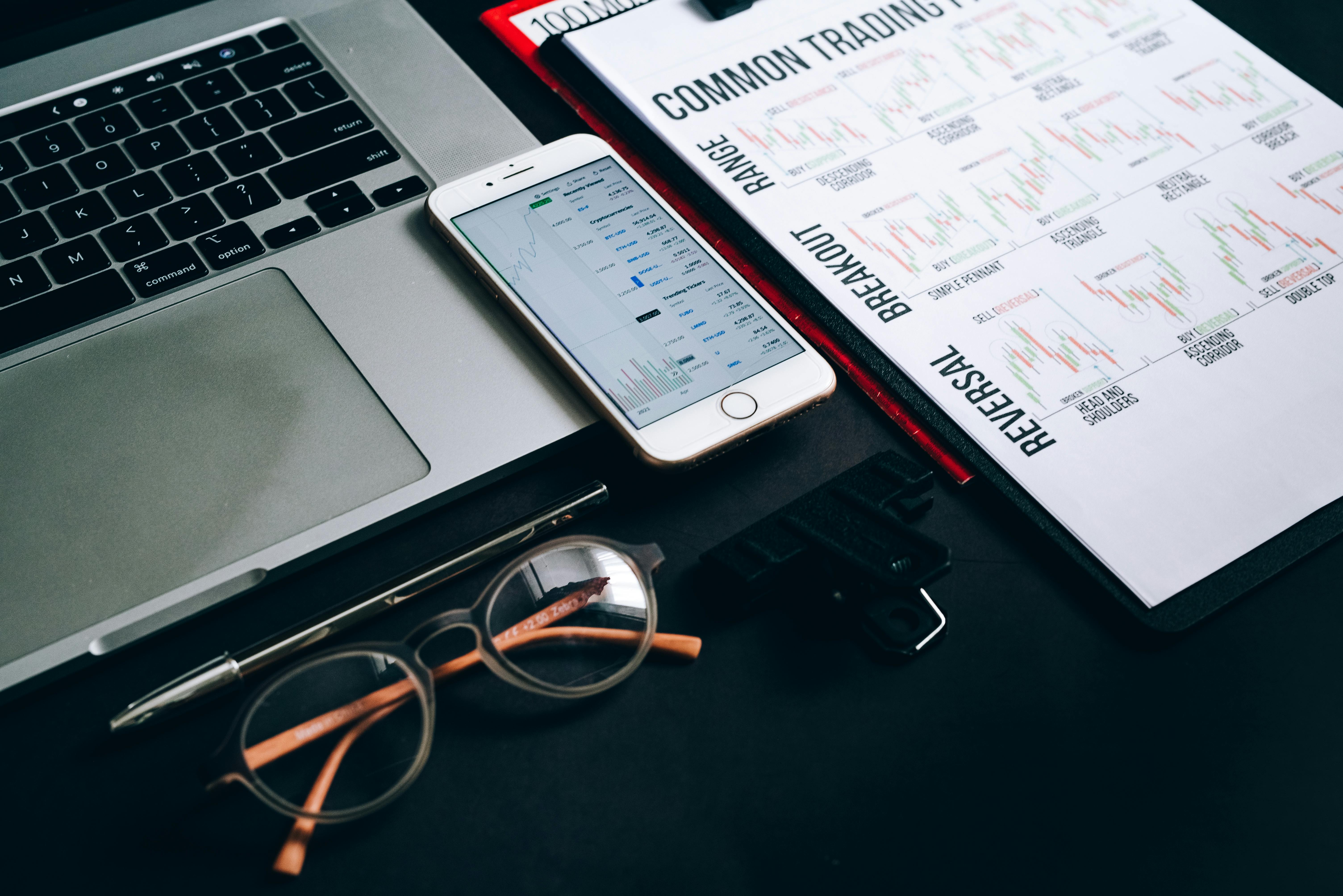 Two White Printer Papers Near Macbook on Brown Surface · Free Stock Photo