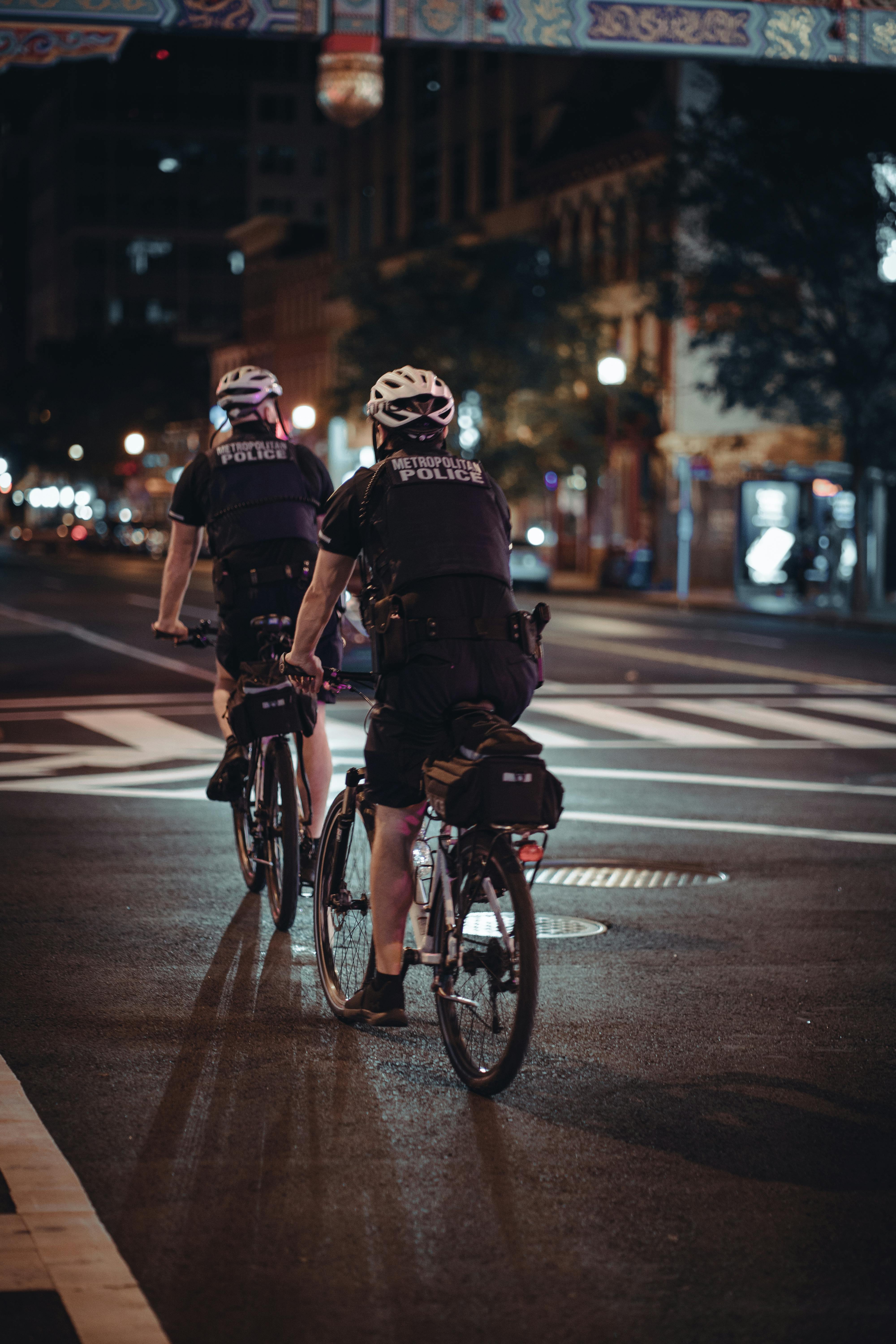 Policemen Riding on Bicycles on Street at Night Time · Free Stock Photo