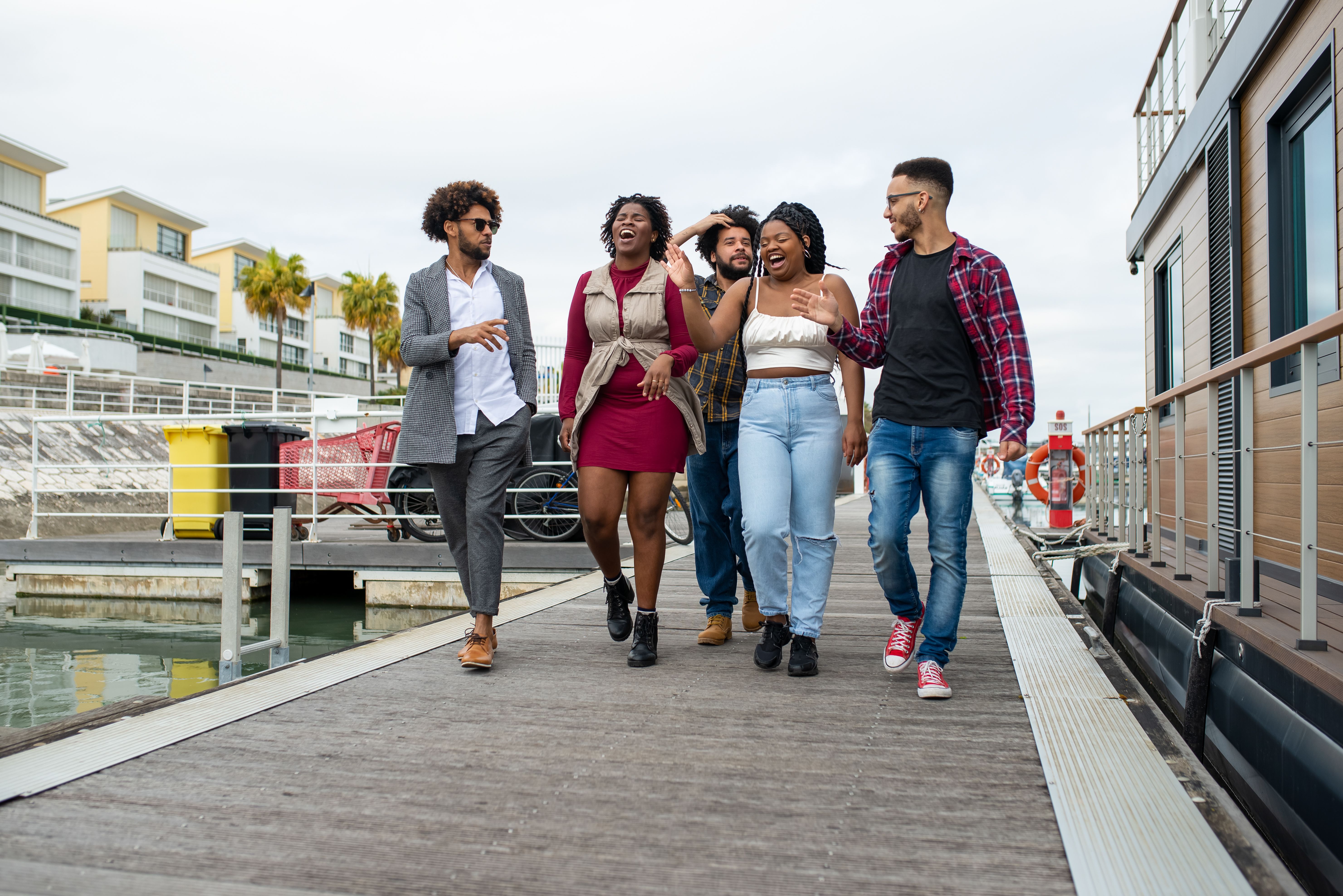 Group of Happy People Walking on Boardwalk · Free Stock Photo