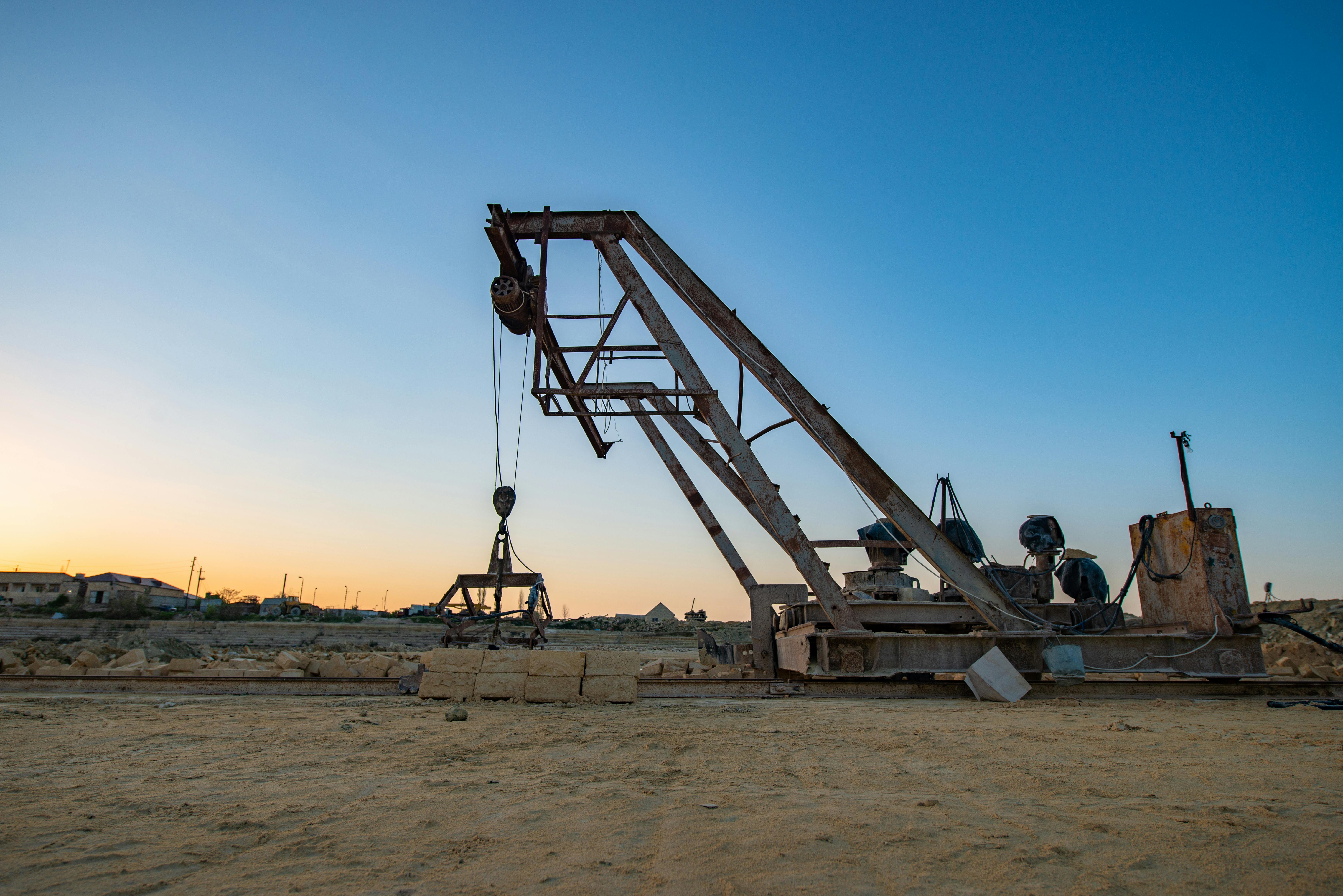 A Rusty Broken Crane Equipment on Sand · Free Stock Photo