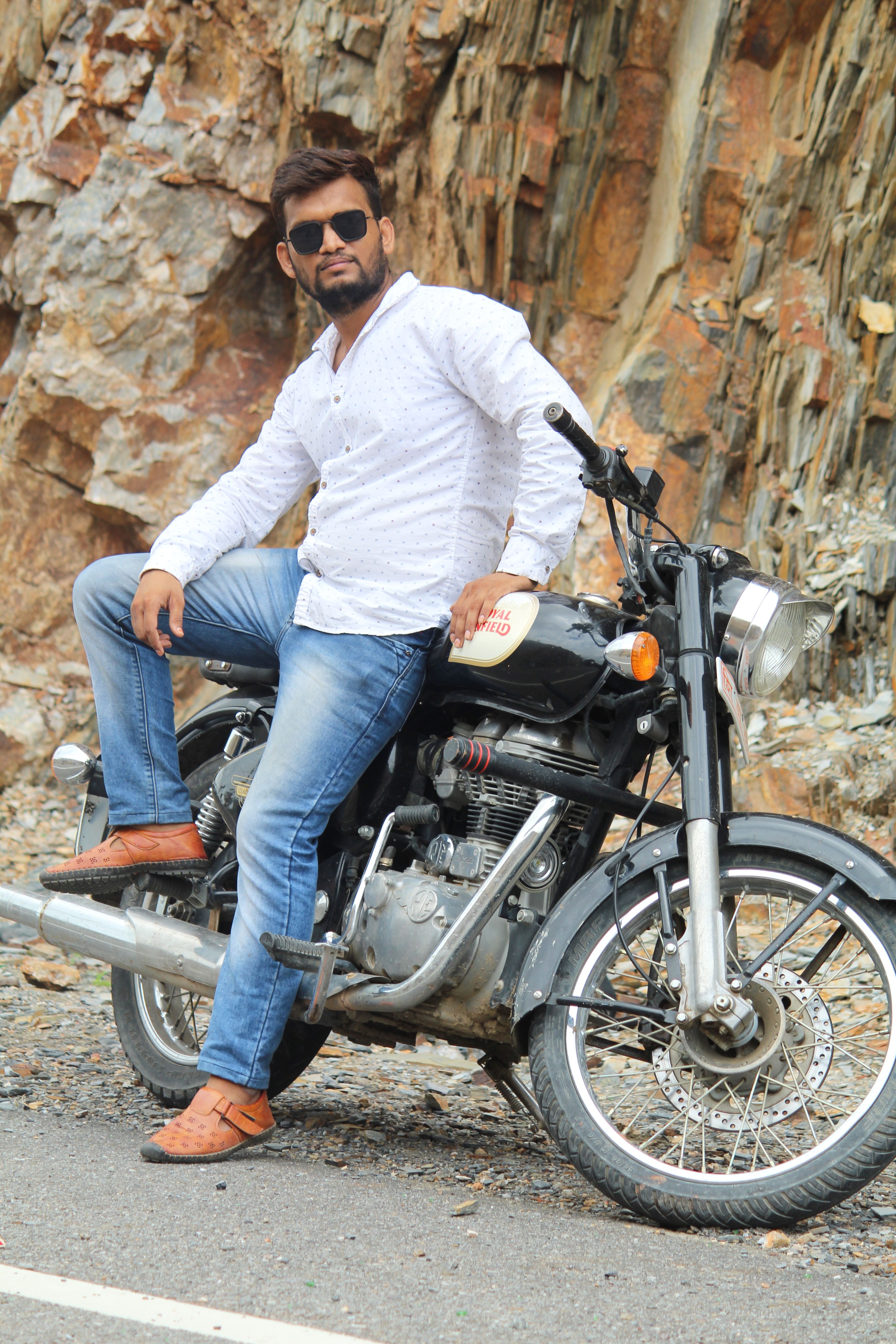 Man Standing on Tip Toes with his Arms Raised next to a Motorcycle ...