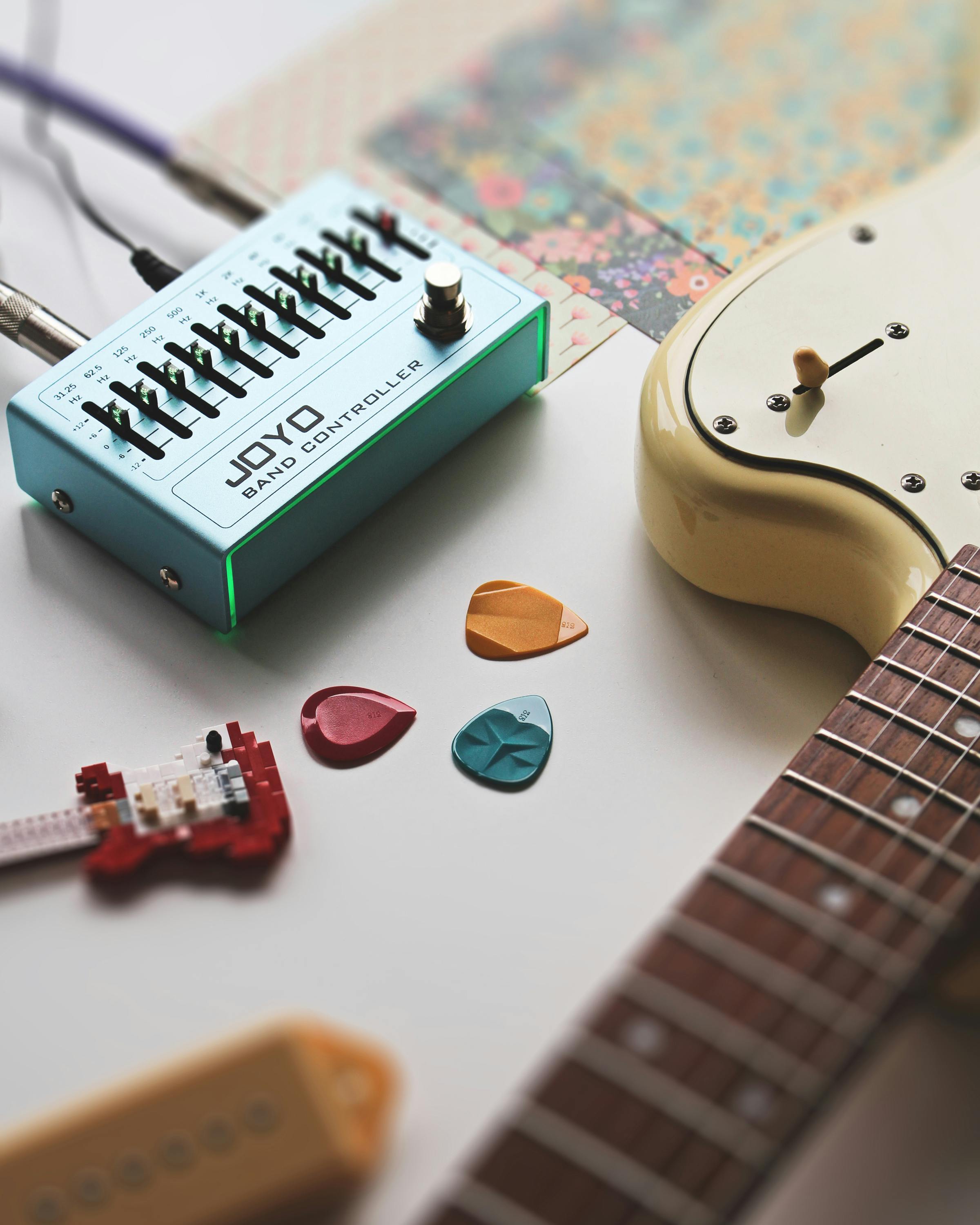 Guitar Picks Beside a Joyo Band Controller and a Guitar · Free Stock Photo