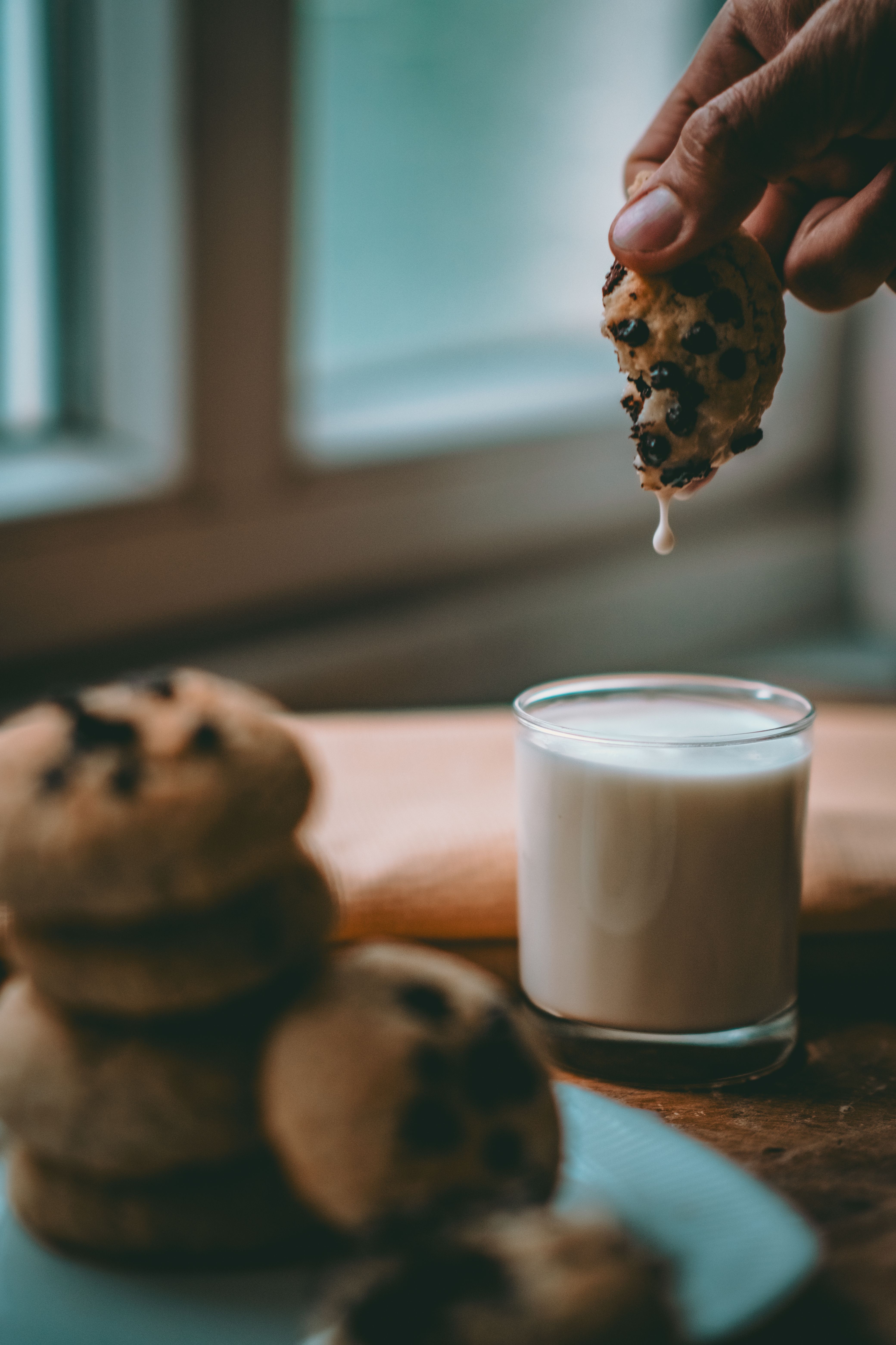 Person Dipping a Cookie in Milk · Free Stock Photo