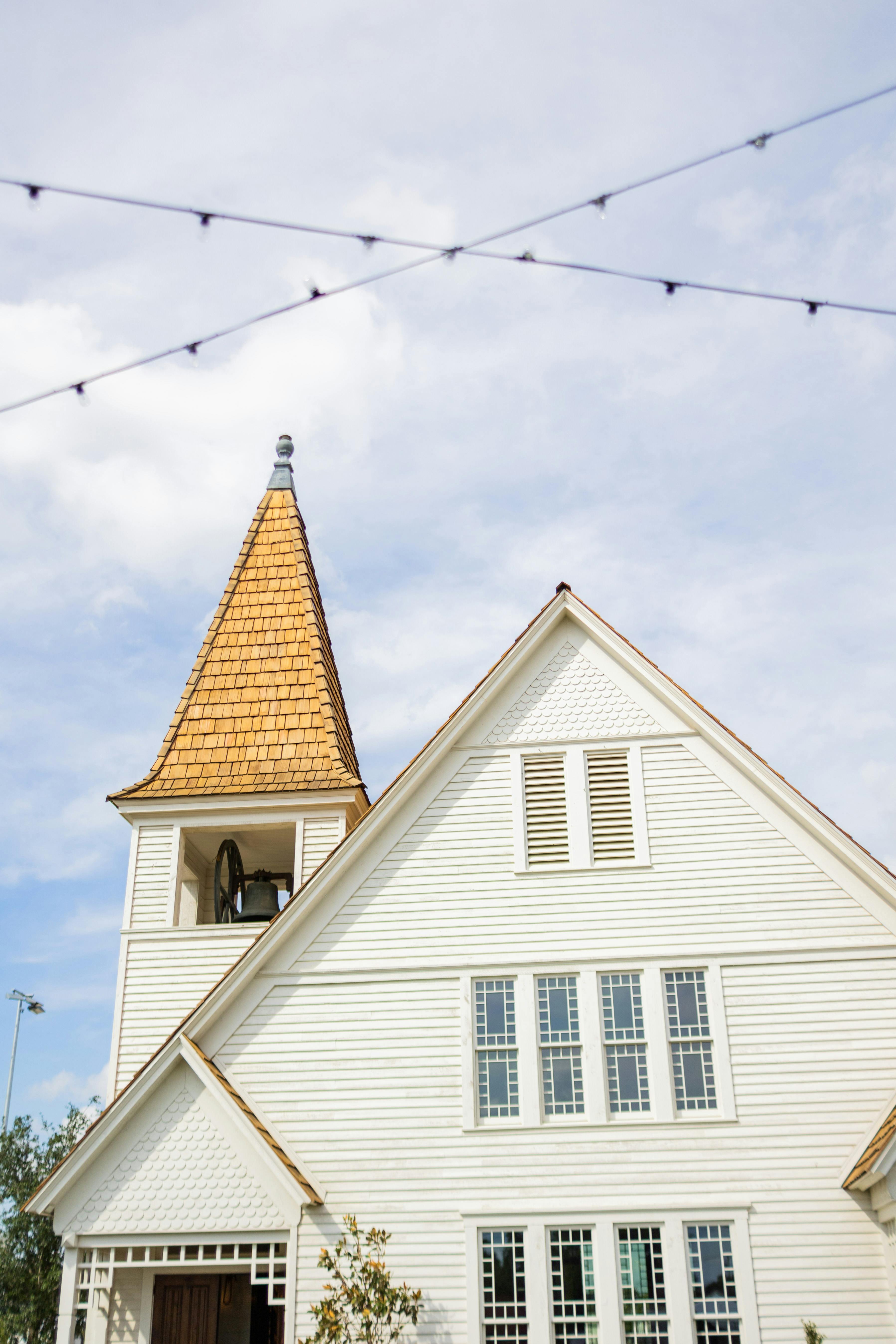 Roof Of A Church With Cross and Bells Under Cloudy Sky · Free Stock Photo