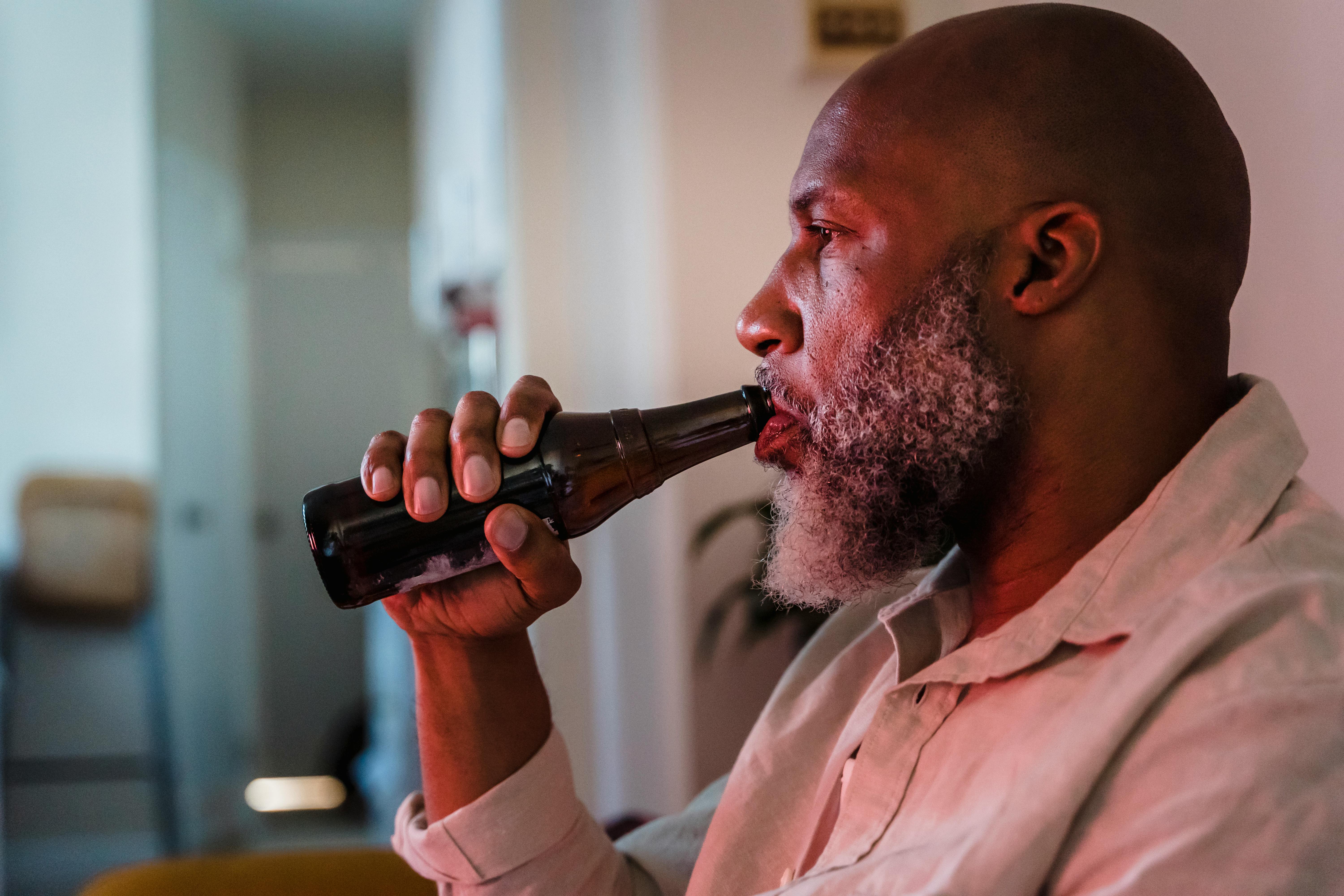 Old Man Drinking Beer from Bottle · Free Stock Photo