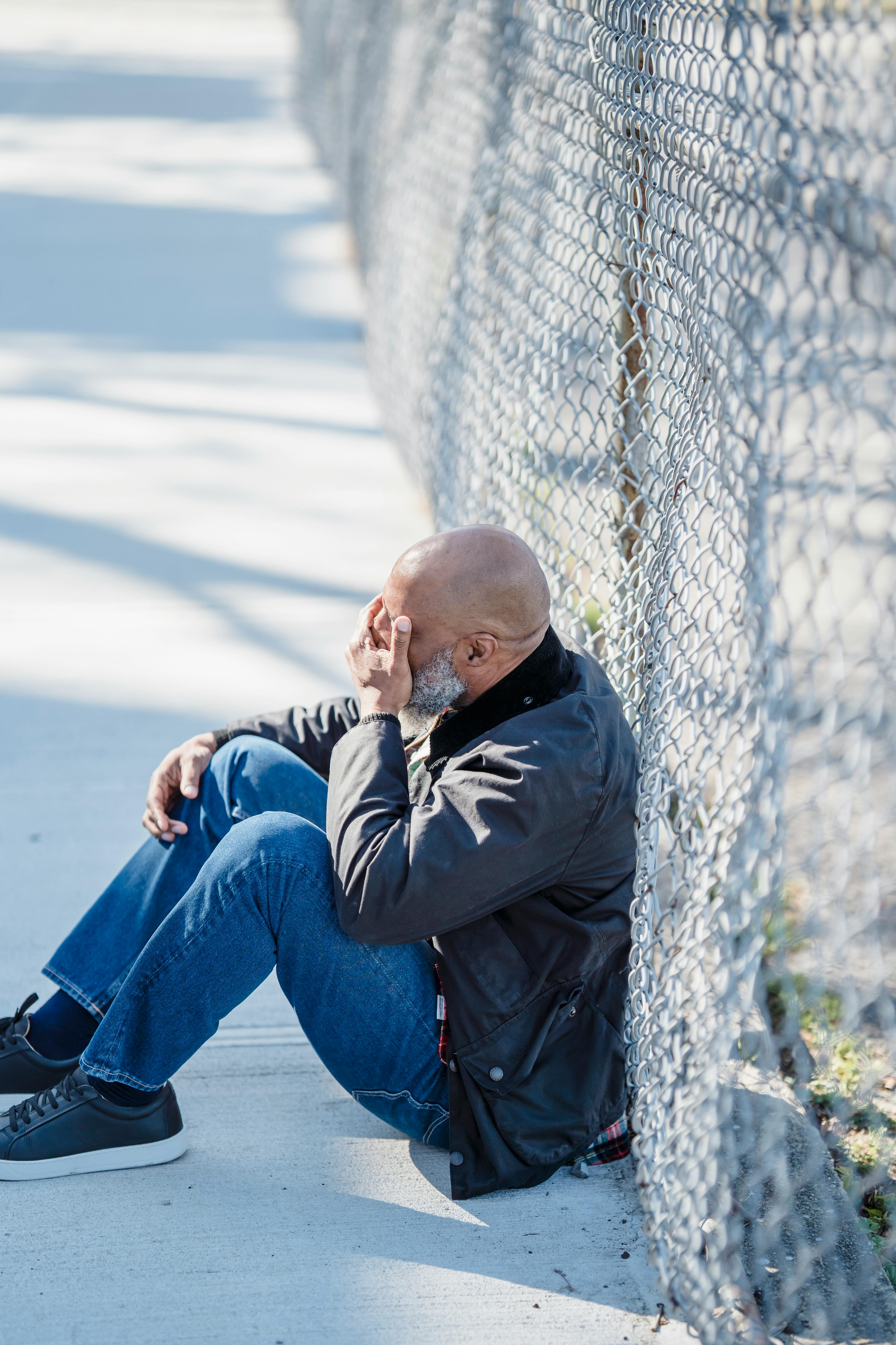 A Homeless Man Eating on a Sidewalk · Free Stock Photo