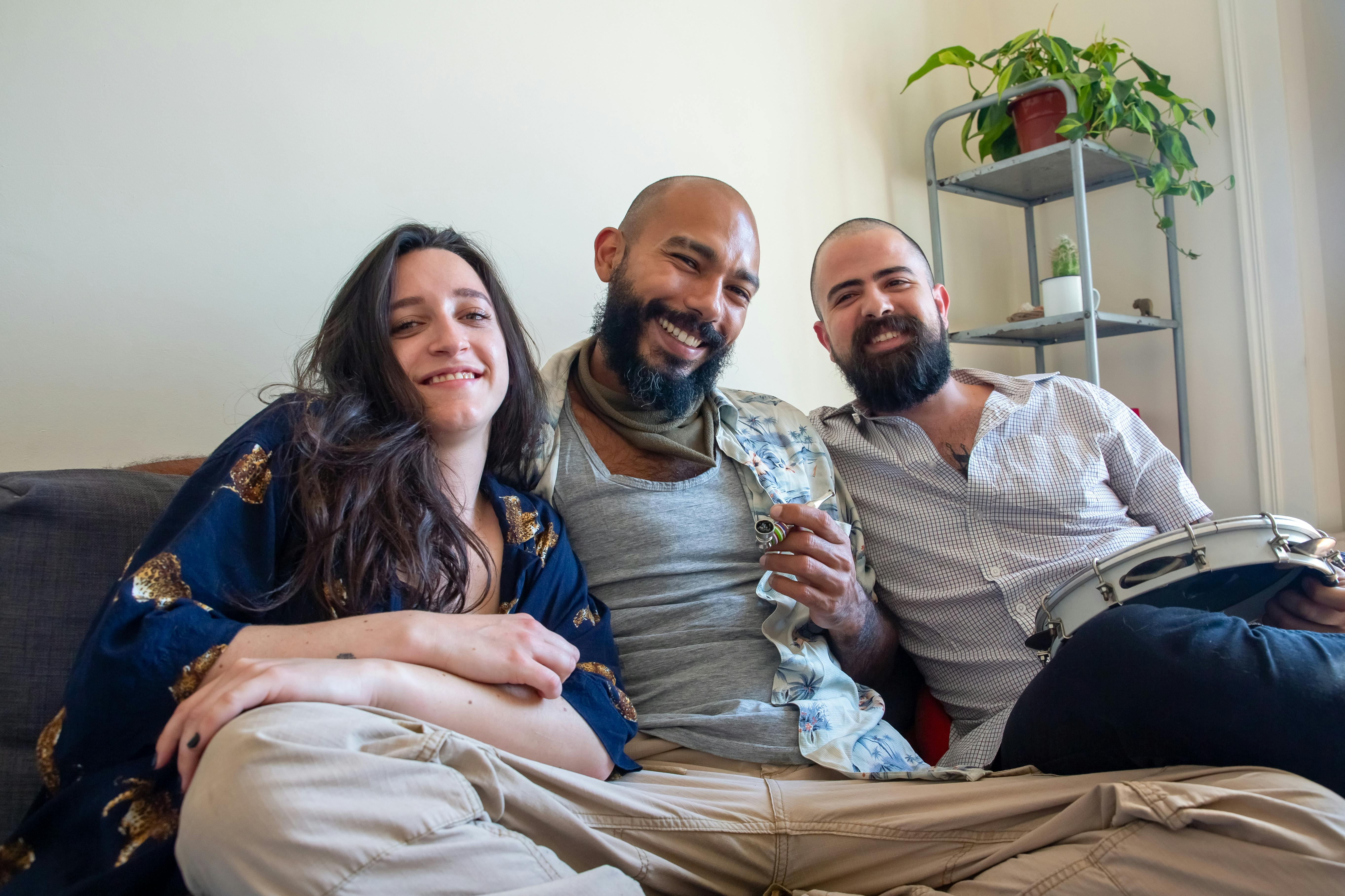 Three People Sitting on a Couch Looking at Camera · Free Stock Photo
