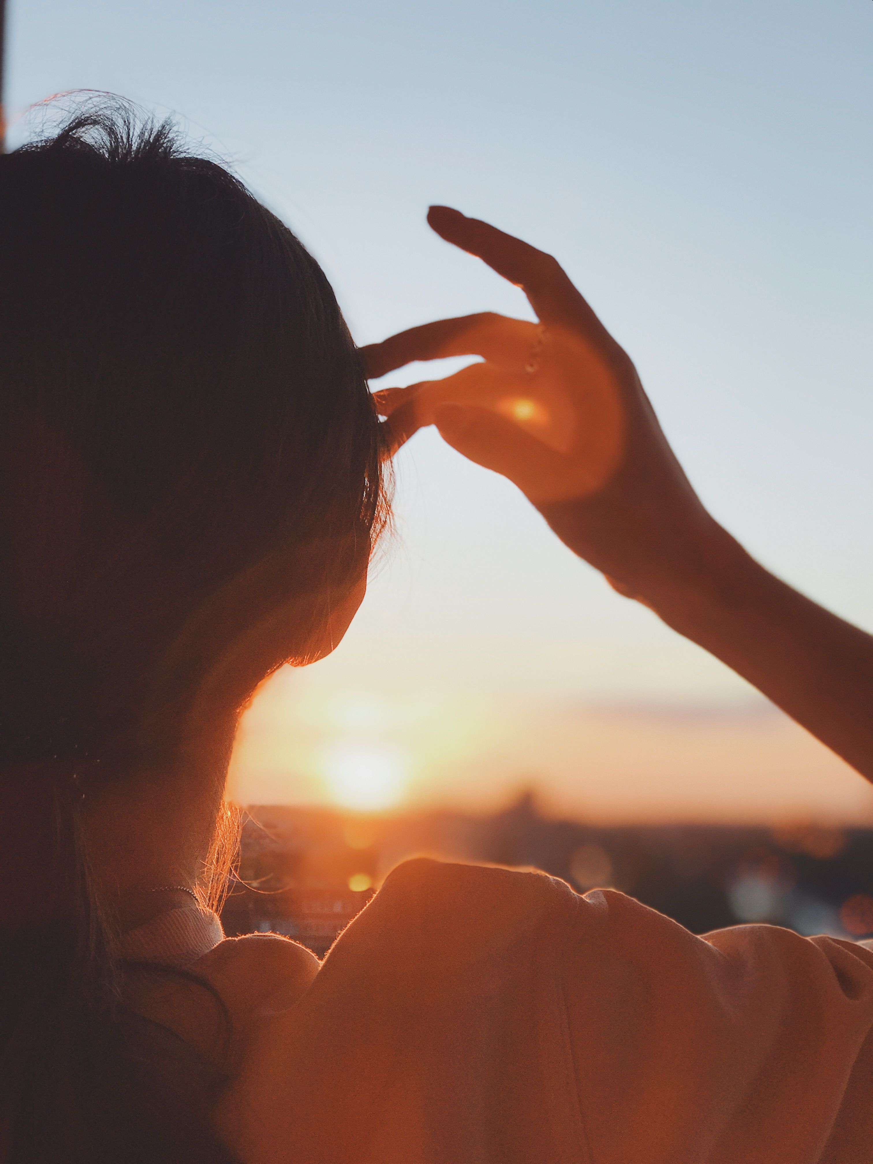 Back of a Woman Fixing her Hair on a Roof · Free Stock Photo