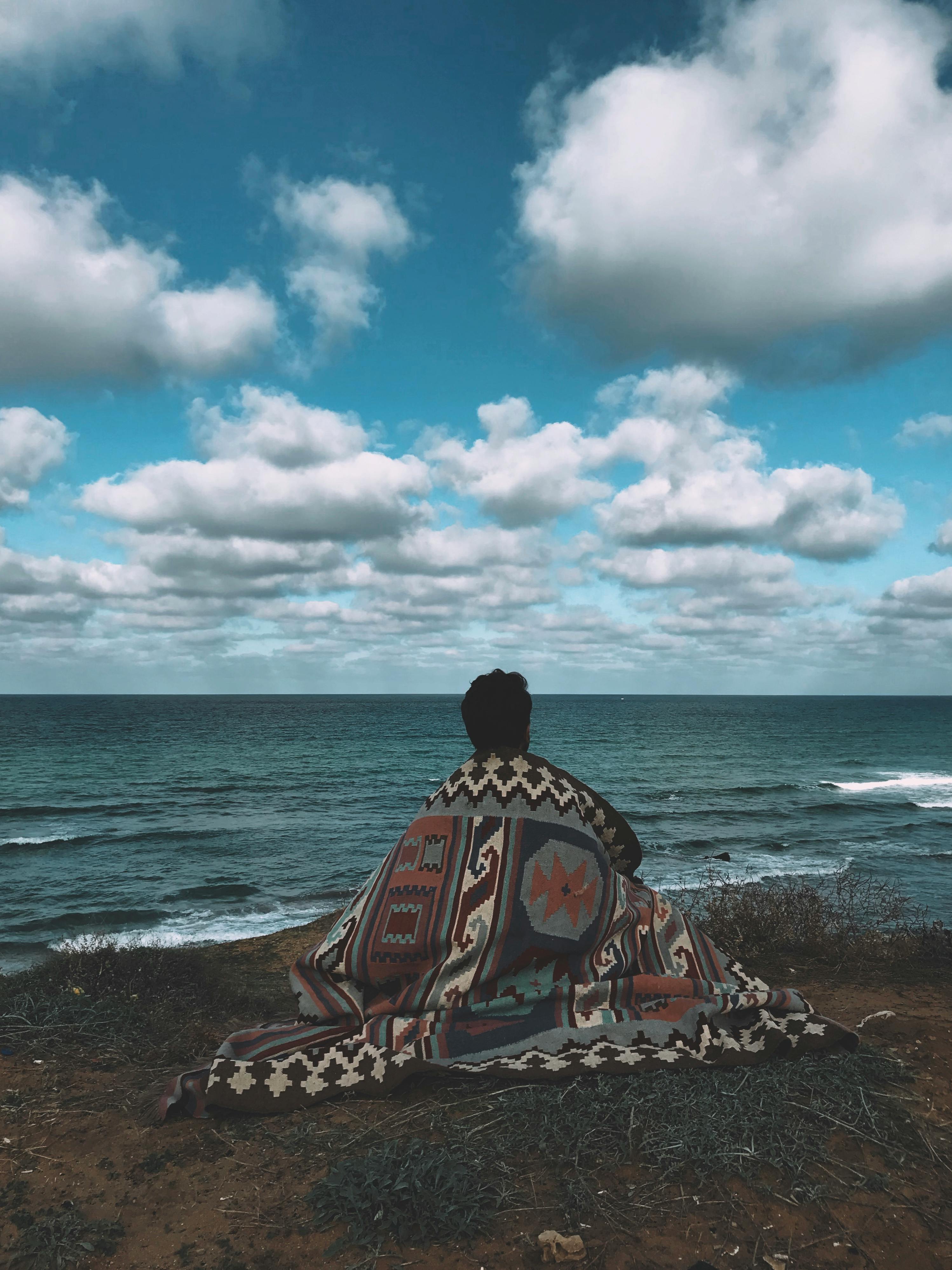 Man sitting on coast and admiring waving sea · Free Stock Photo