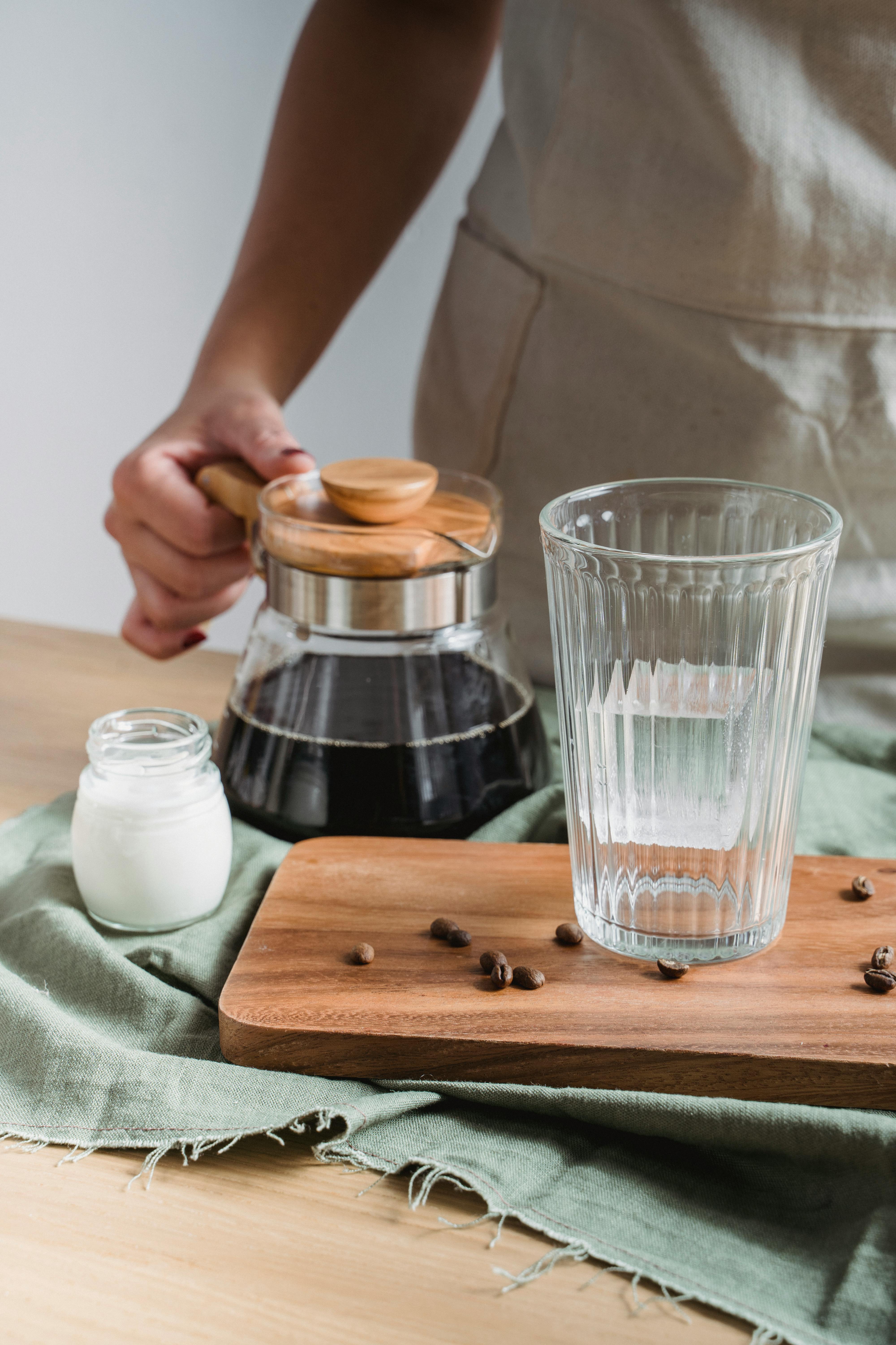 A Person Holding a Glass Pitcher of Coffee · Free Stock Photo