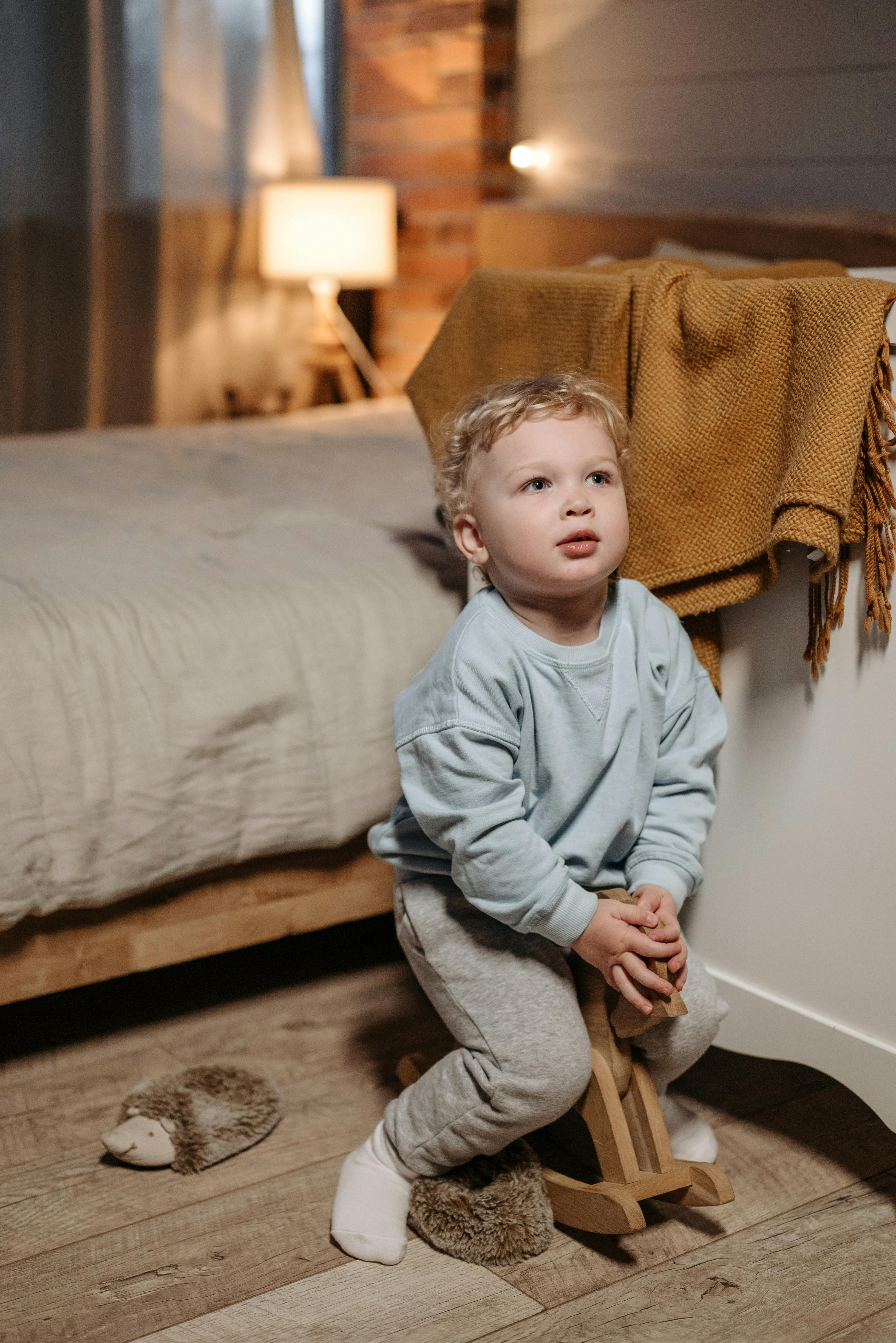 A Cute Boy Riding a Wooden Rocking Horse · Free Stock Photo