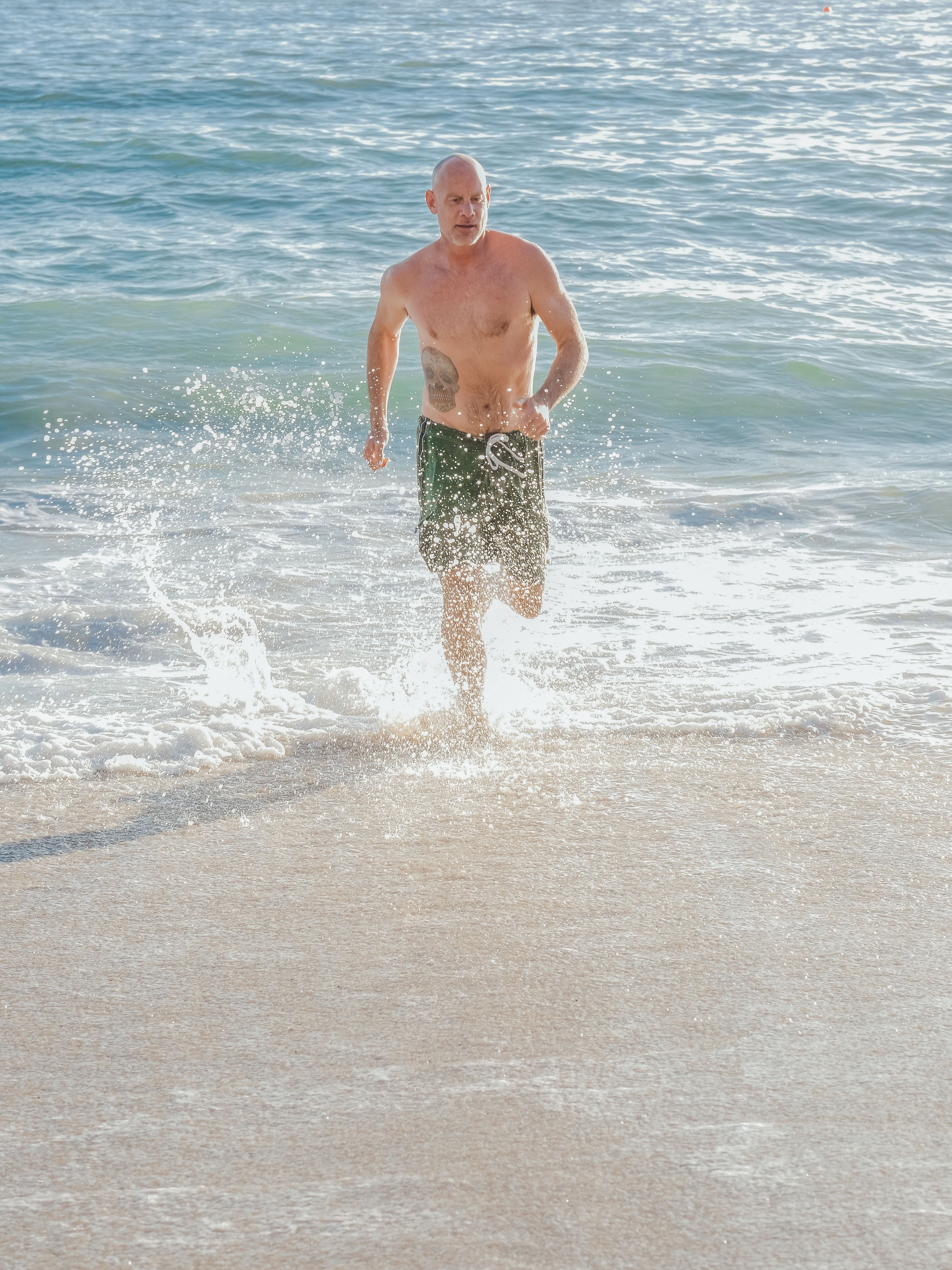 A Shirtless Man Running at the Beach · Free Stock Photo
