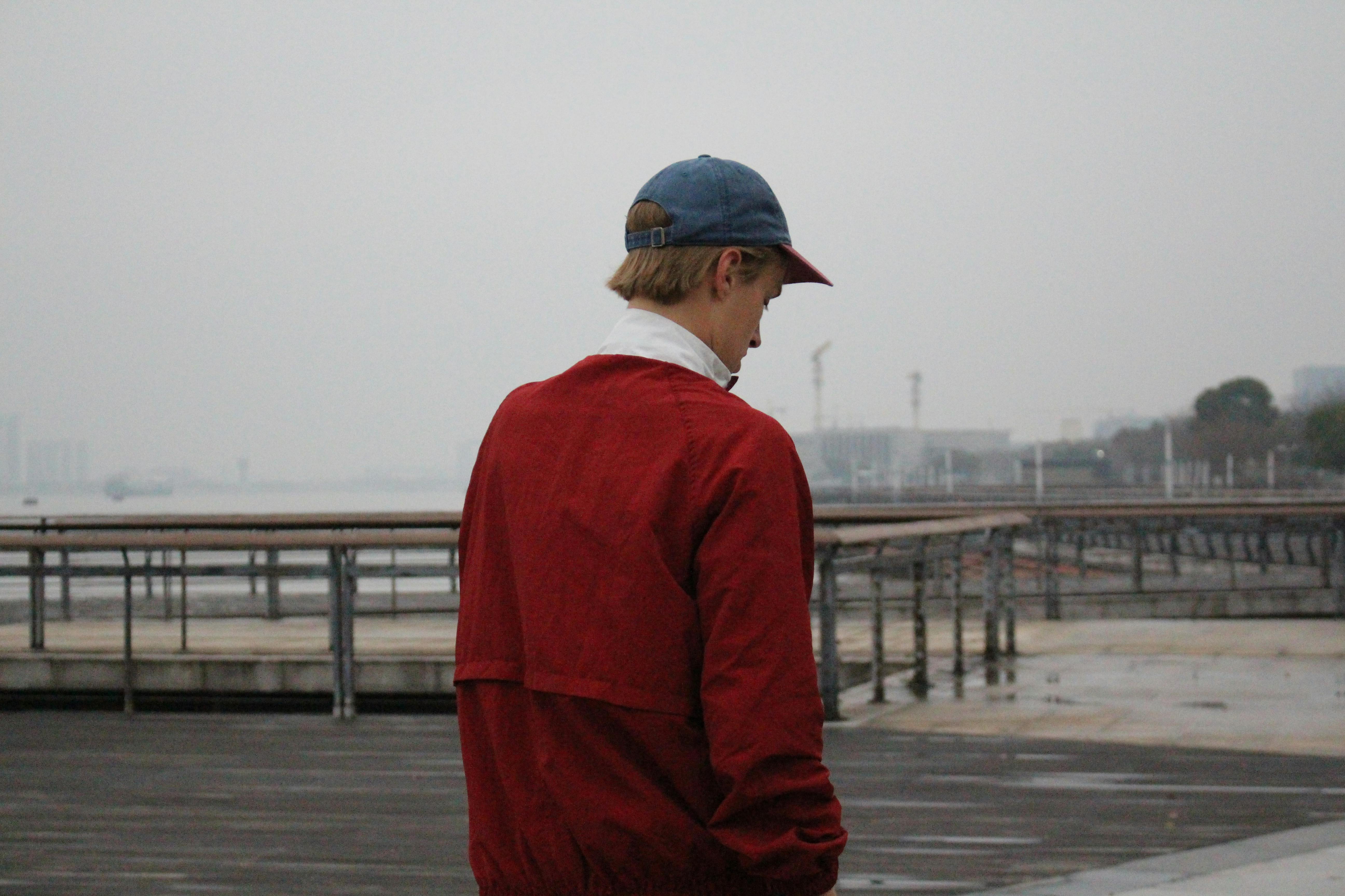 A Man with a Cap Looking Down · Free Stock Photo