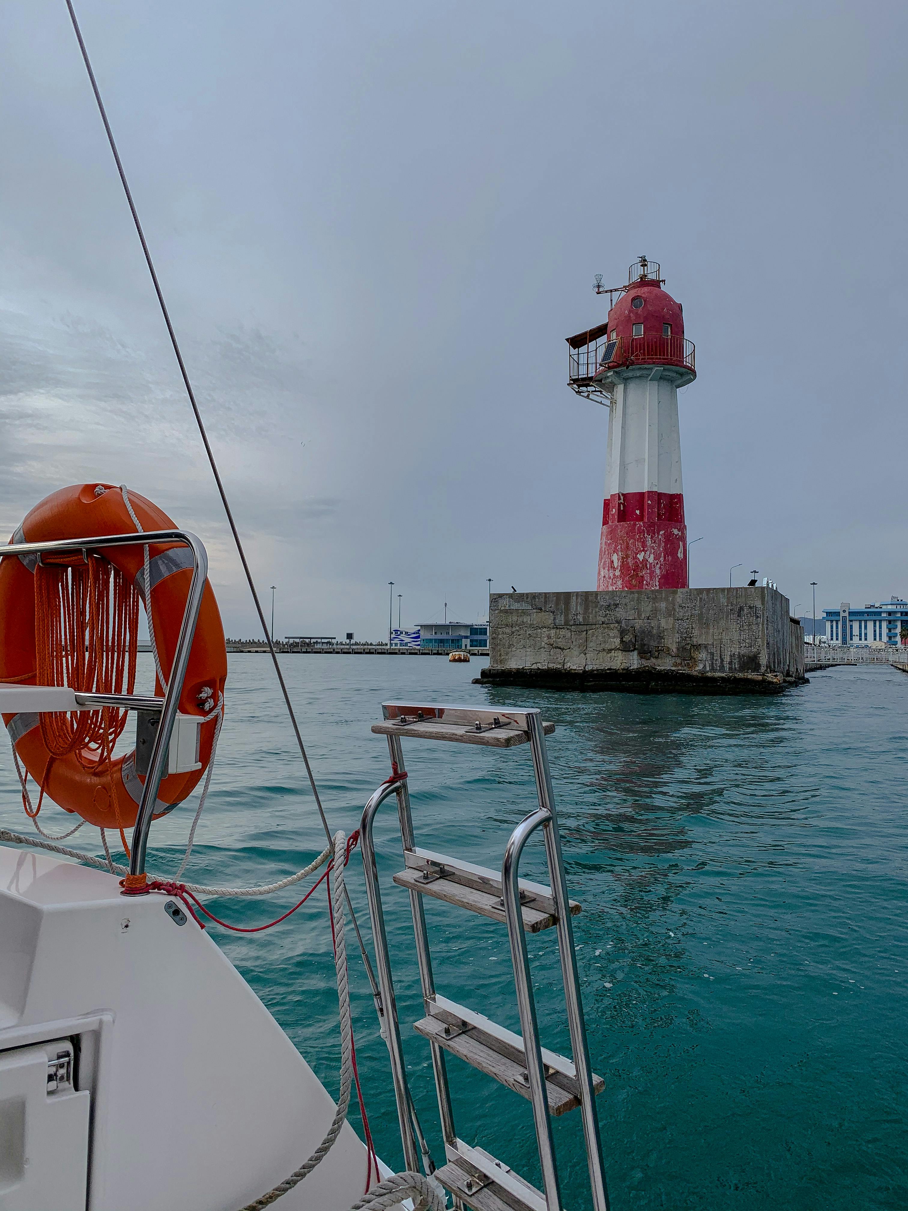 Red and White Lighthouse on Concrete Dock · Free Stock Photo