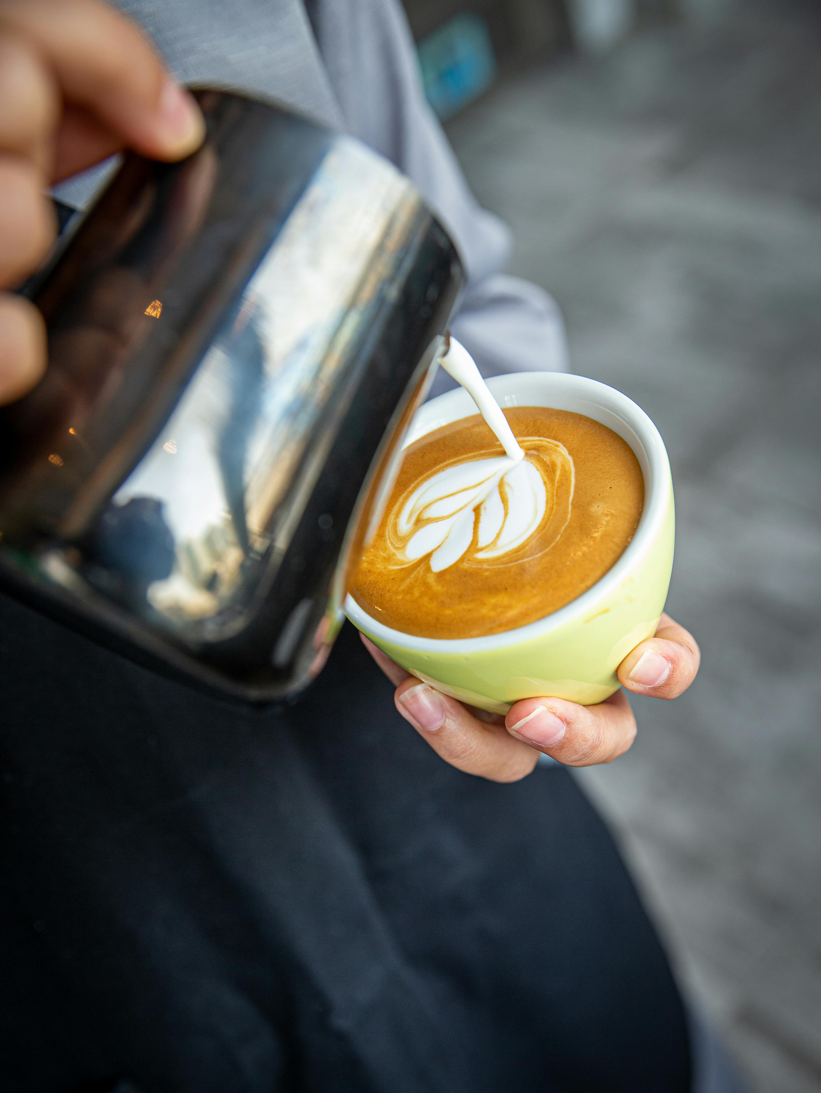 A Person Pouring Steamed Milk into a Cup · Free Stock Photo
