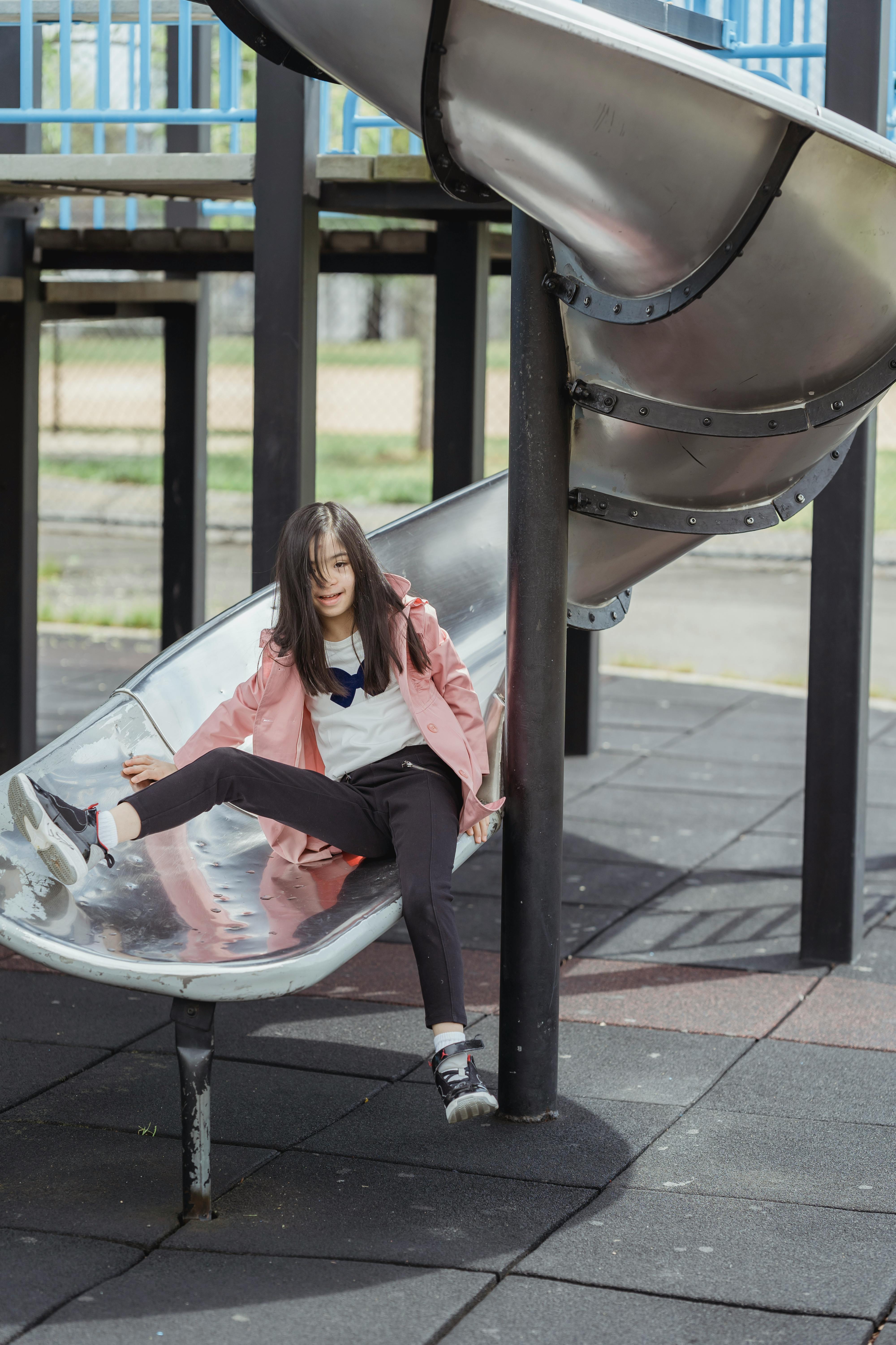 A Girl Sitting on a Slide · Free Stock Photo