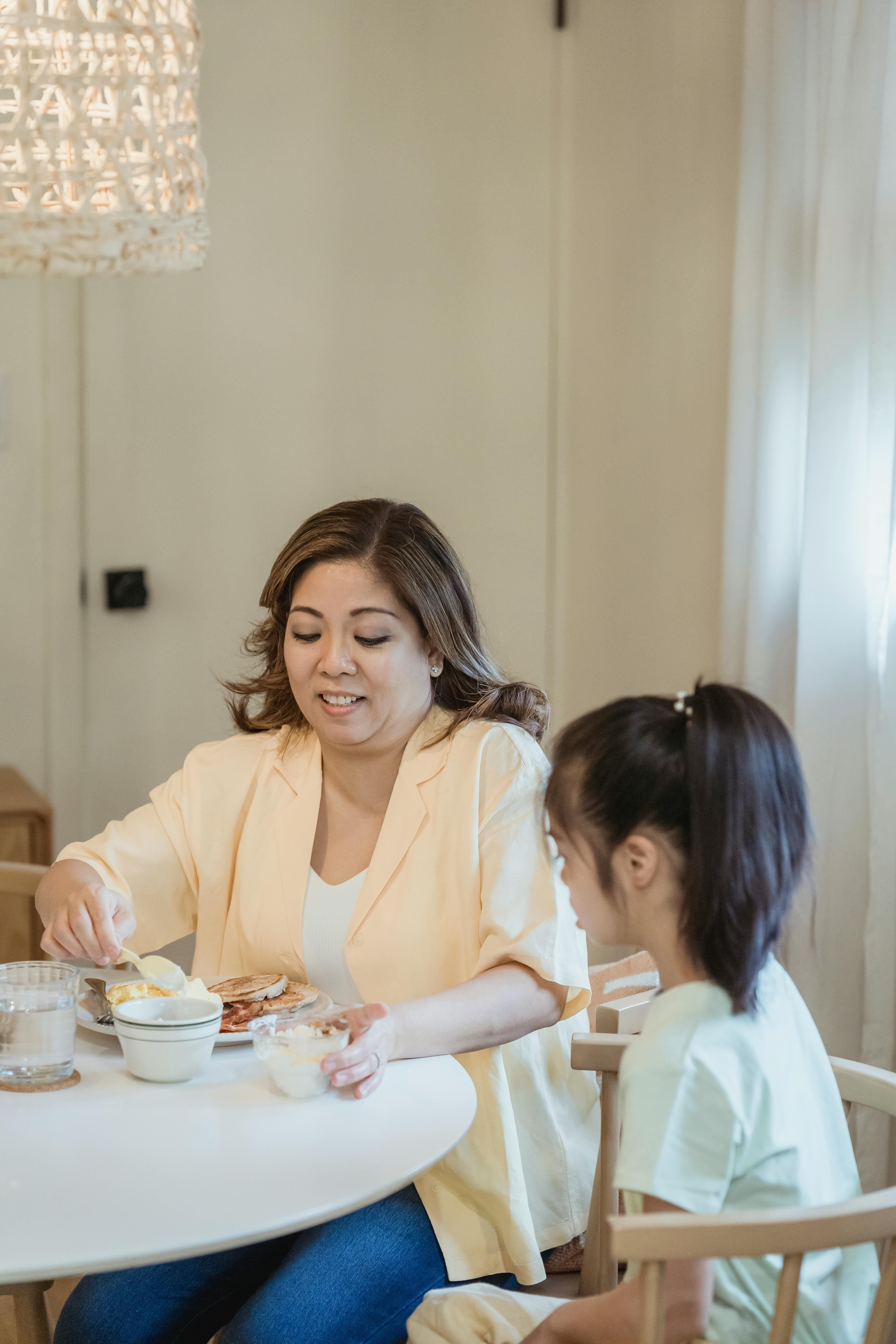 A Woman Sitting Near the Table with Food with Her Daughter · Free Stock ...