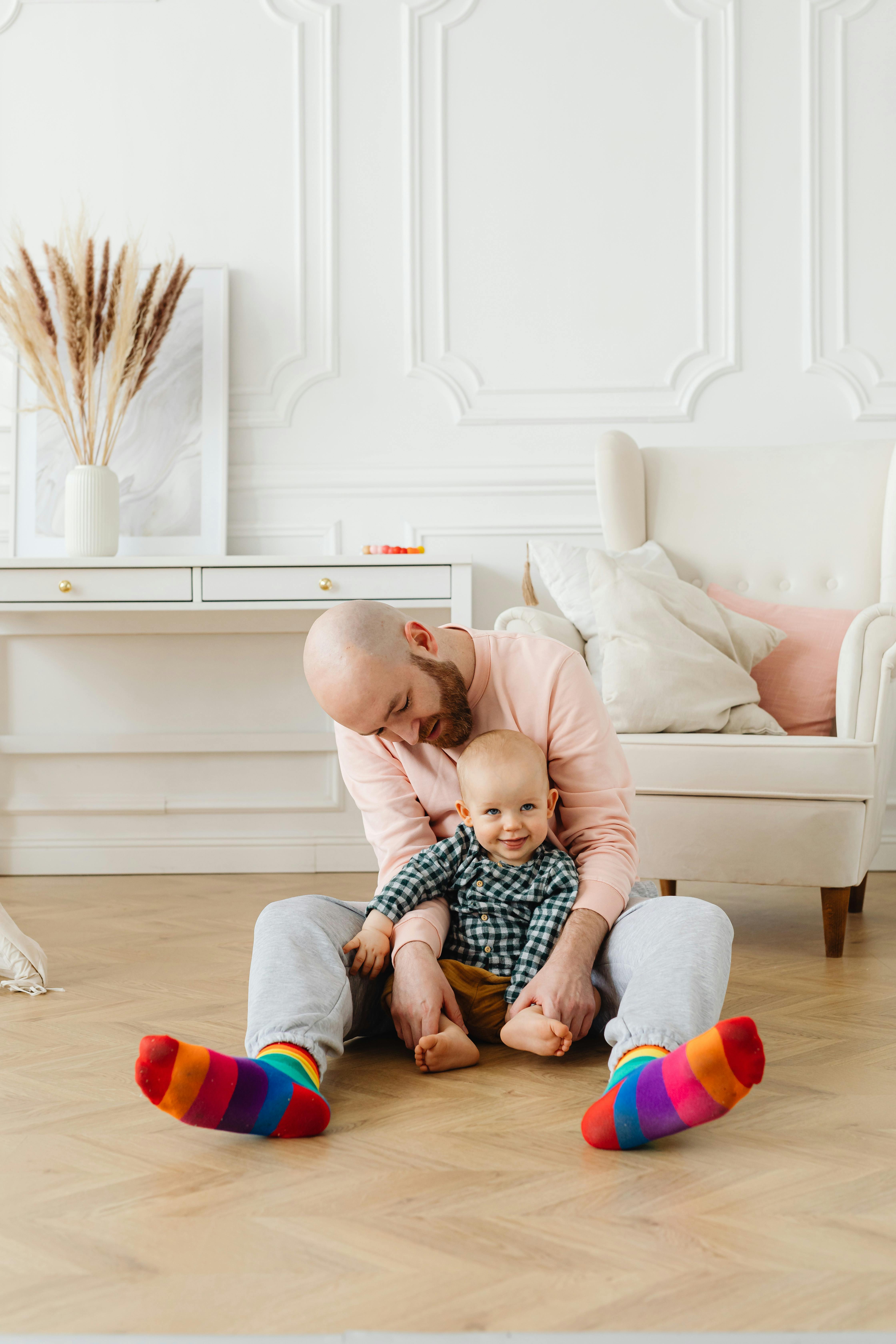 Man Sitting and Cuddling A Baby · Free Stock Photo