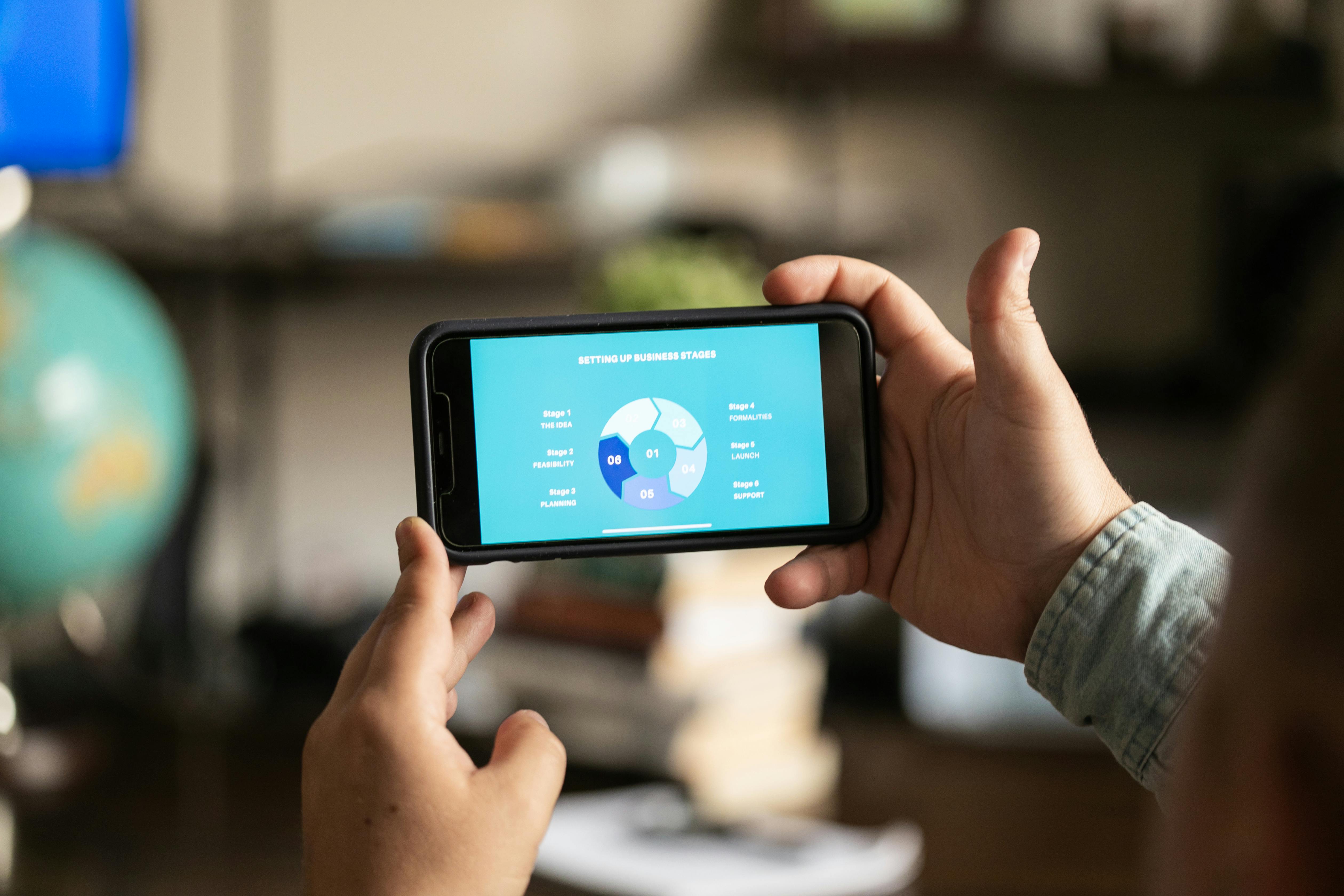 Close-Up Shot of a Person Holding a Smartphone Updating · Free Stock Photo