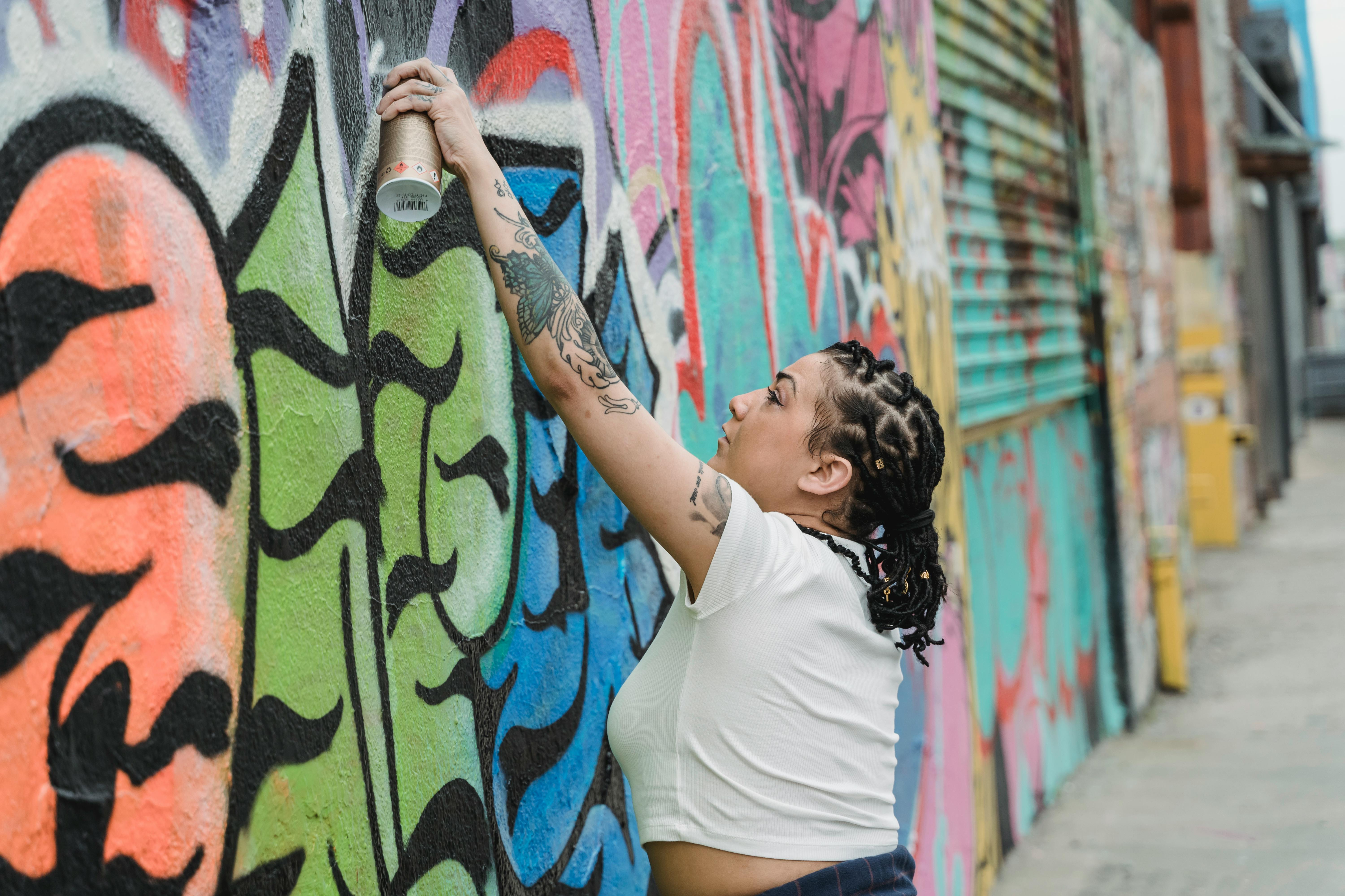 A Woman Spray Painting on the Wall · Free Stock Photo