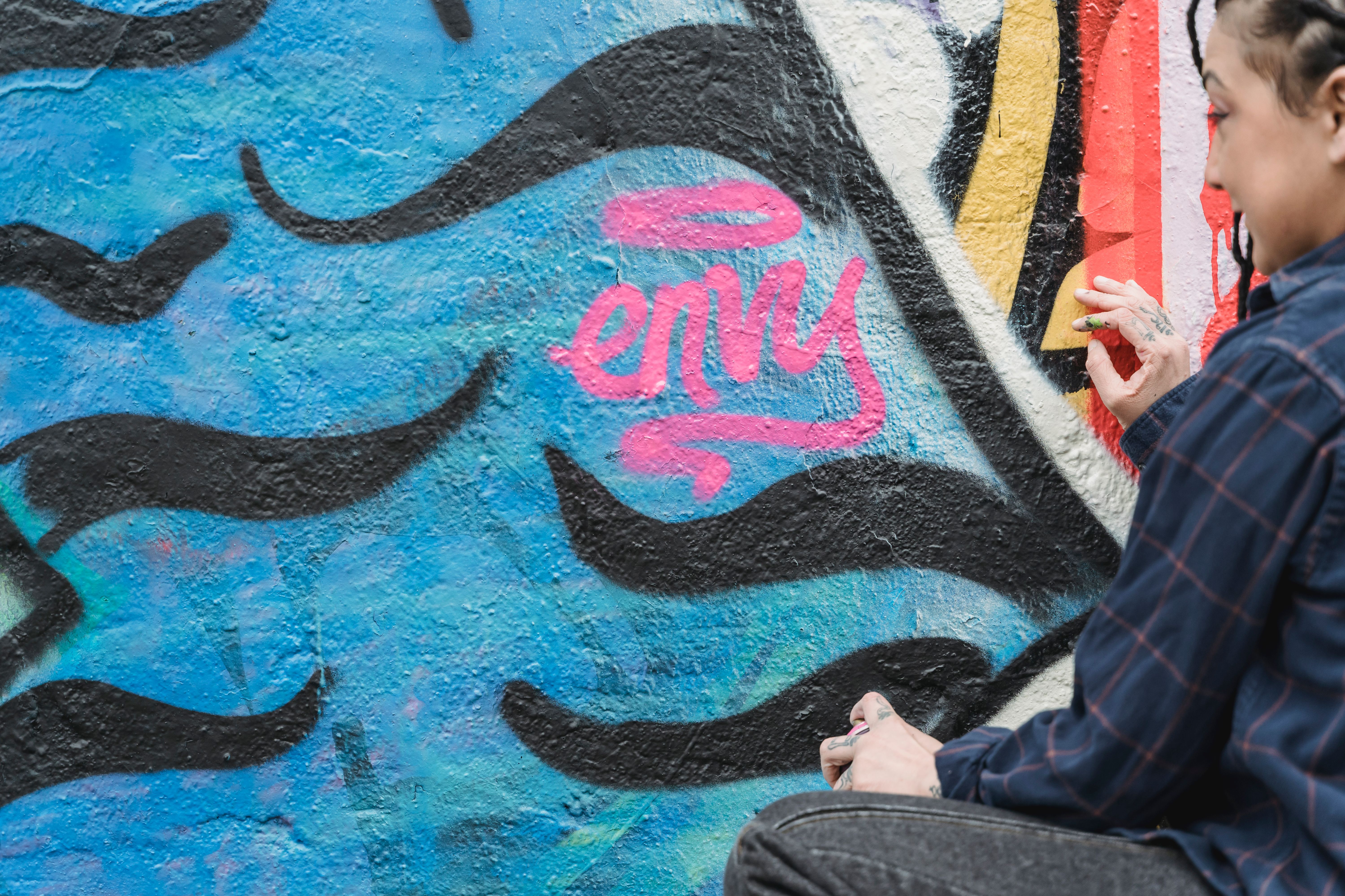 A Woman Spray Painting on the Wall · Free Stock Photo