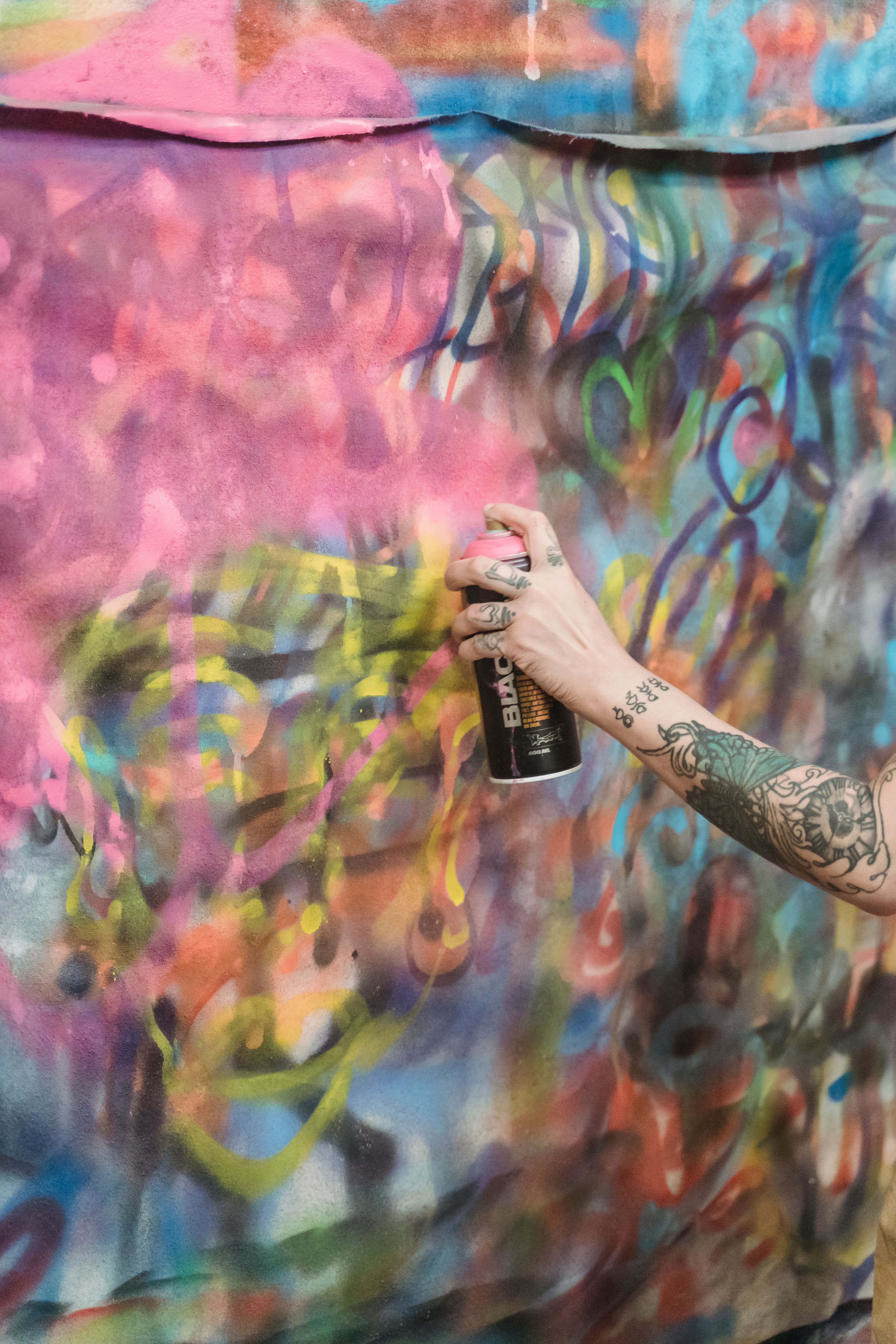 Hand with Tattoos Painting Graffiti on Wall · Free Stock Photo