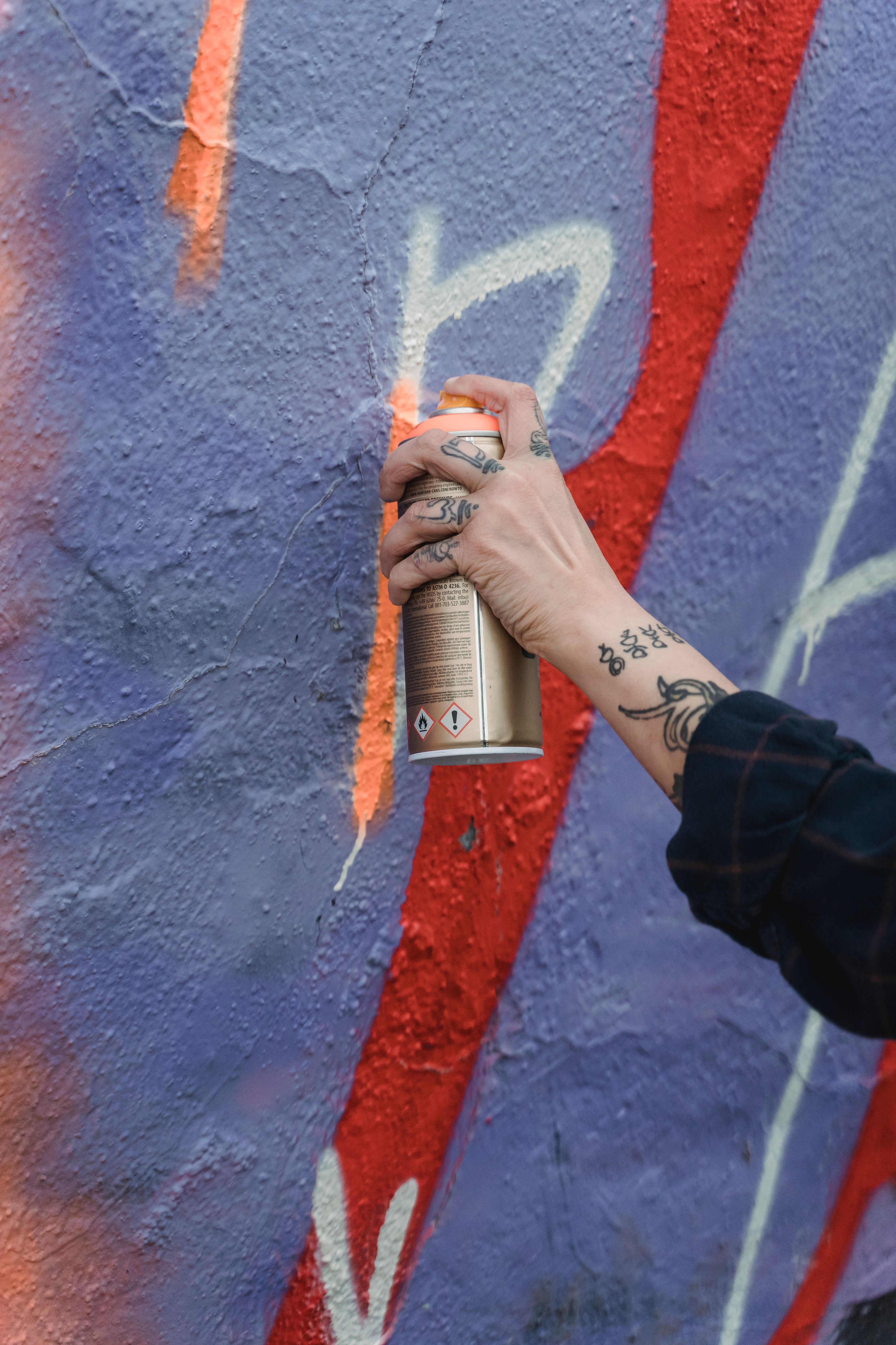 A Person Doing Graffiti on a Wall Using a Spray Paint · Free Stock Photo