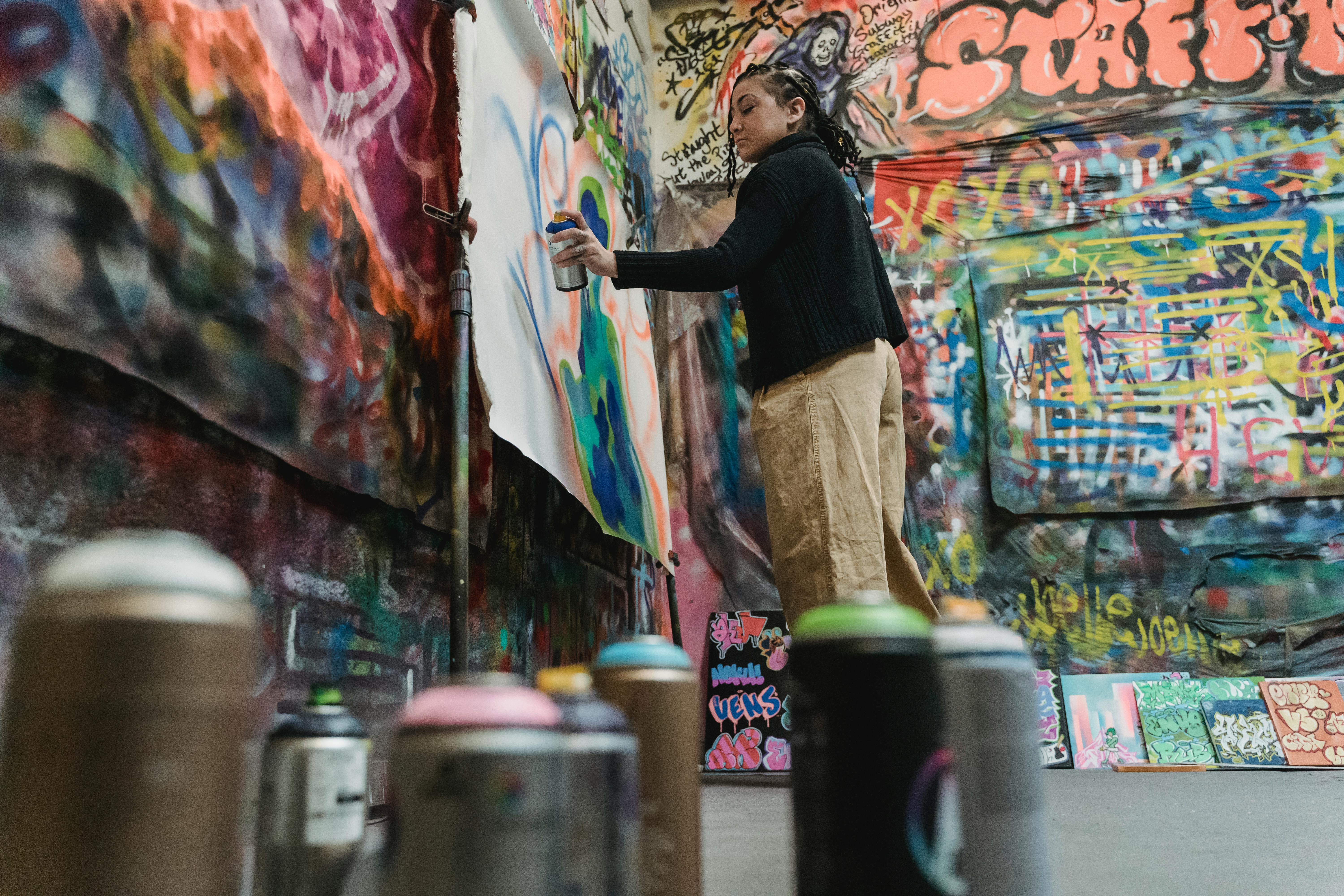 Person in Black Velvet Long Sleeves Holding a Spray Paint · Free Stock ...