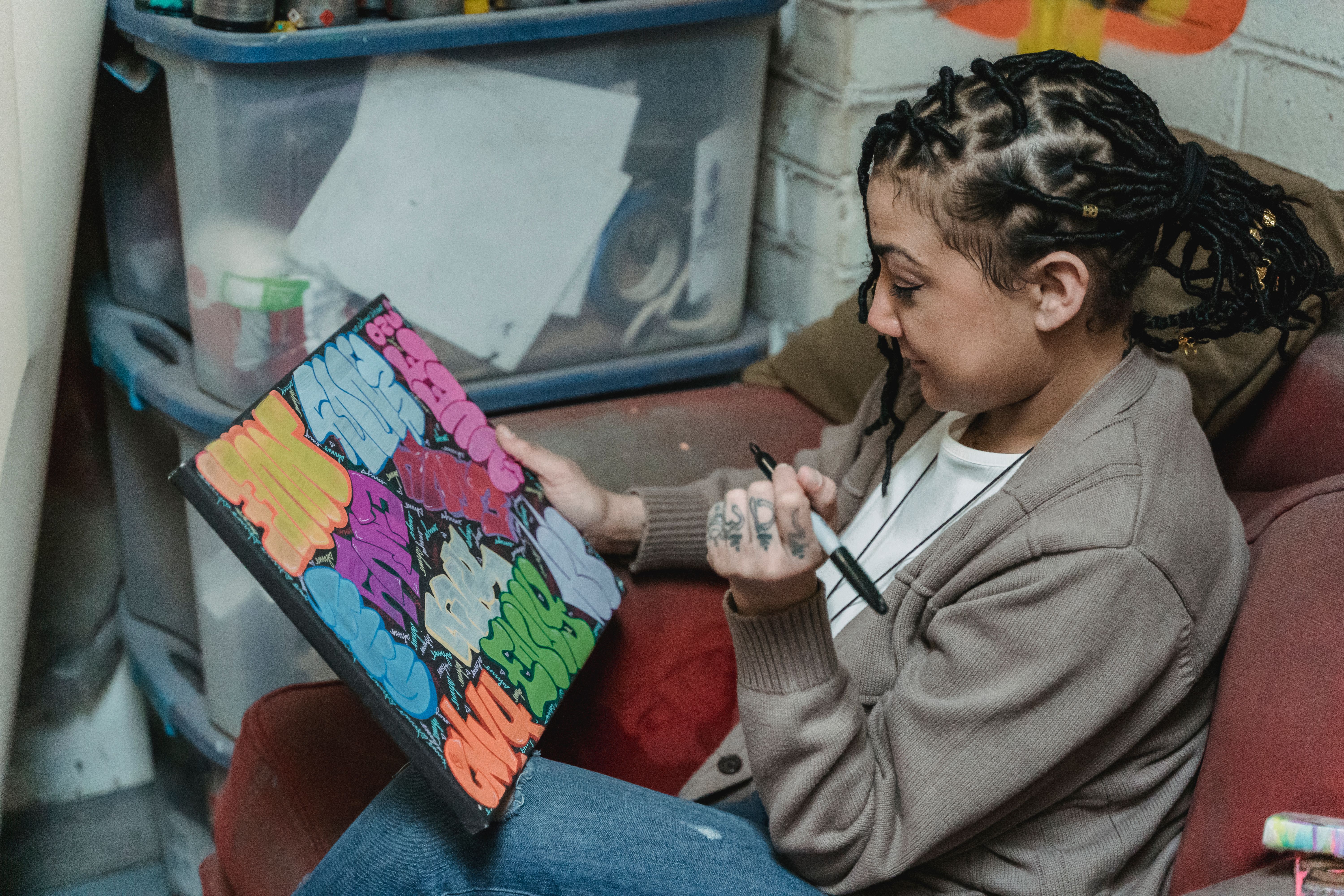 Female Artist making a Sample Grafitti on a Canvas · Free Stock Photo