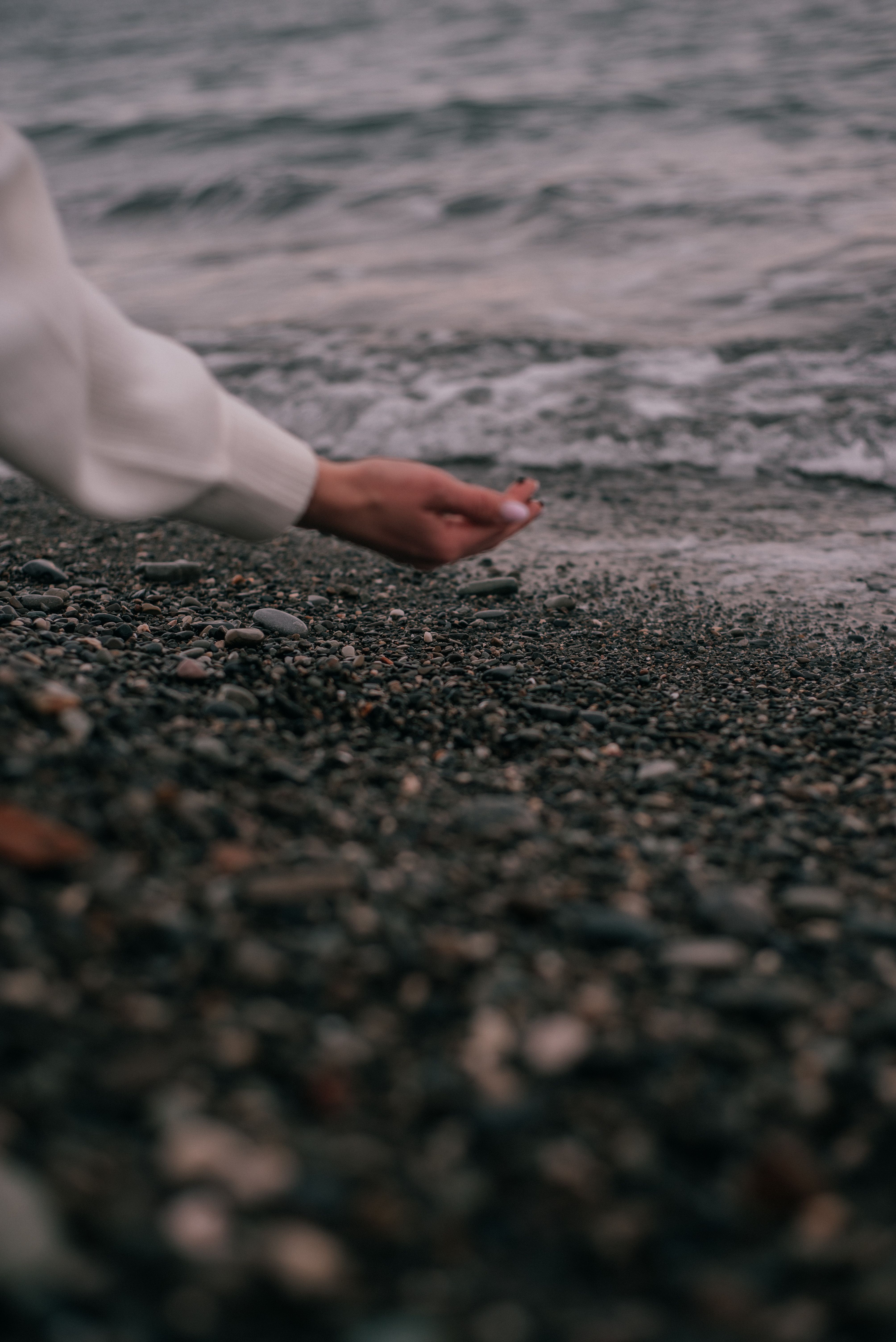 A Person's Hand Near Stones · Free Stock Photo
