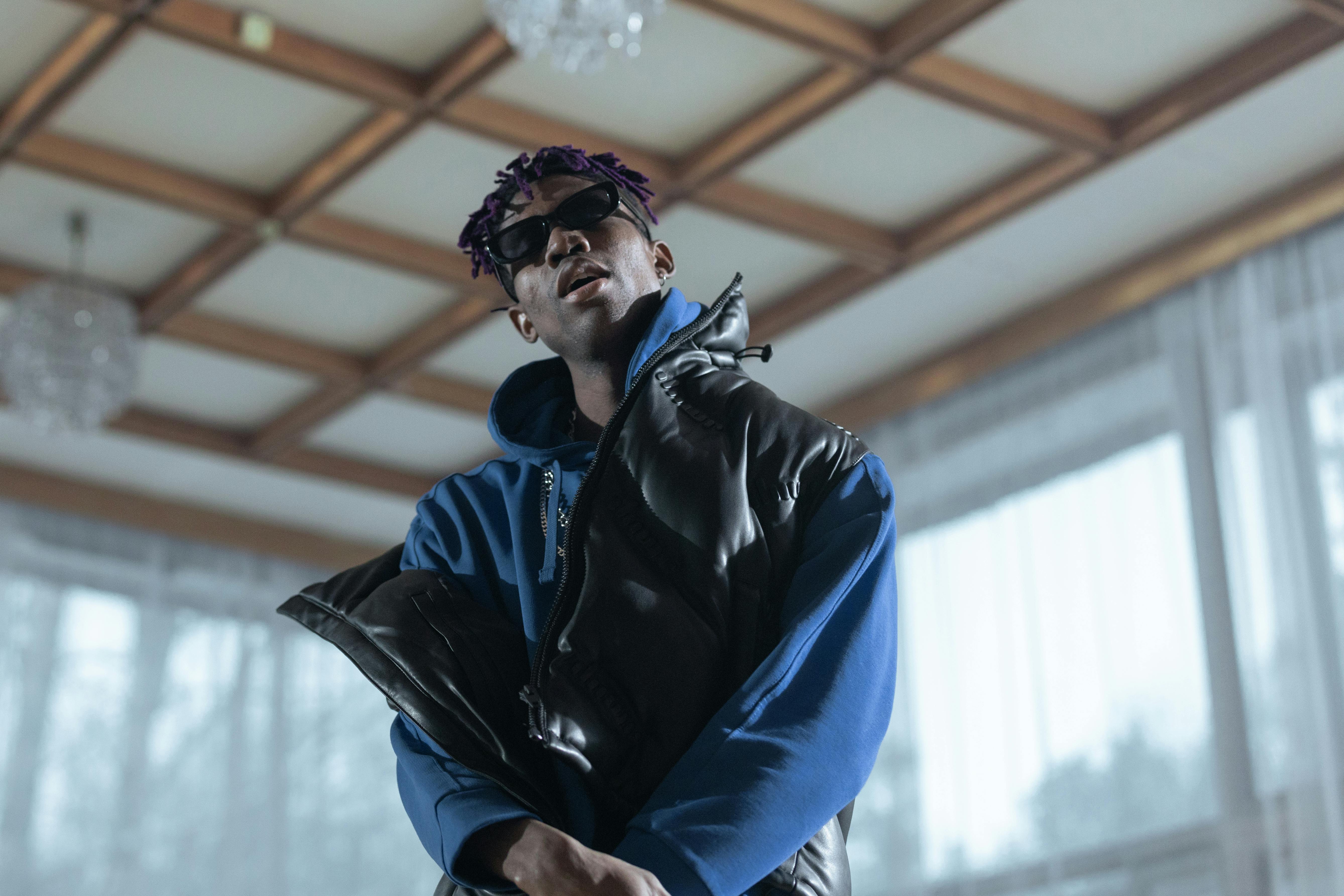 Man With Dreadlocks and Sunglasses Poses Near Tupac Shakur Portrait ...
